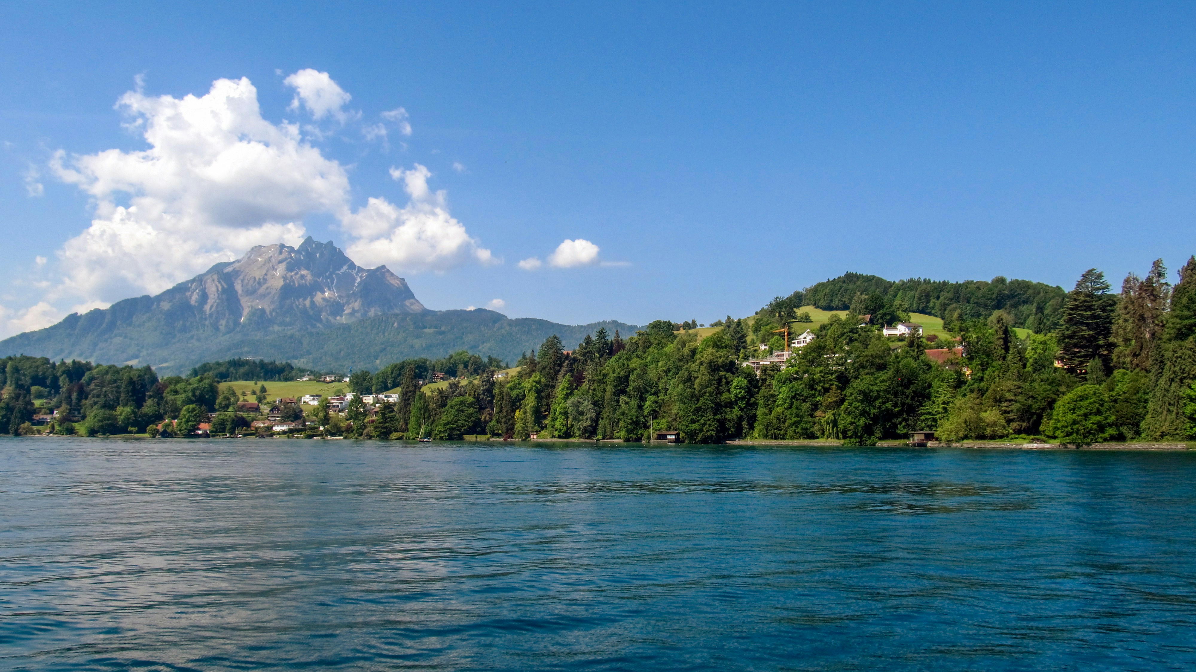 View of Mount Pilatus from a boat trip on Lake Lucerne | a body of water with a mountain in the background