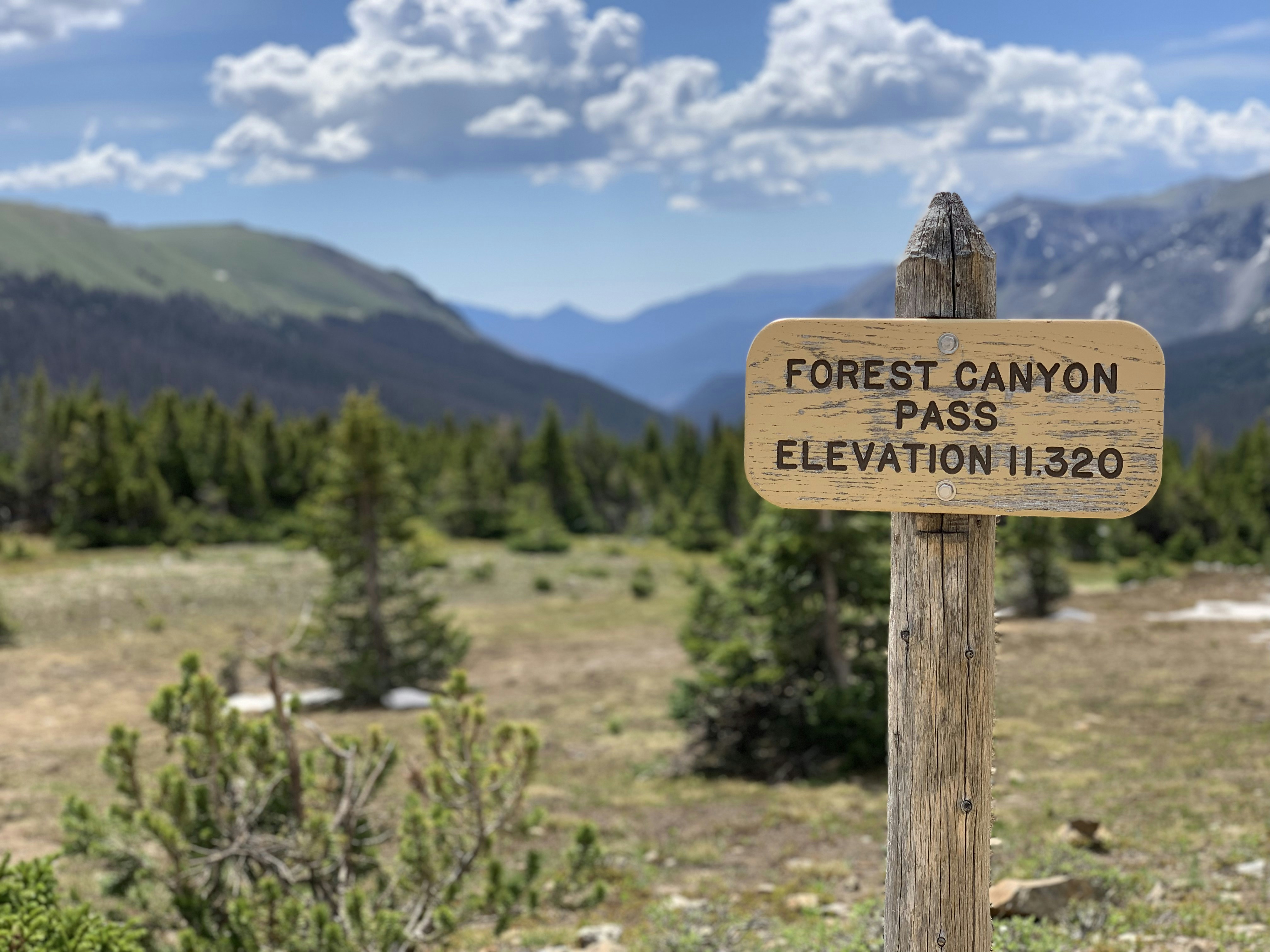 Un panneau sur un poteau au milieu d’un champ photo – Photo Montagnes ...
