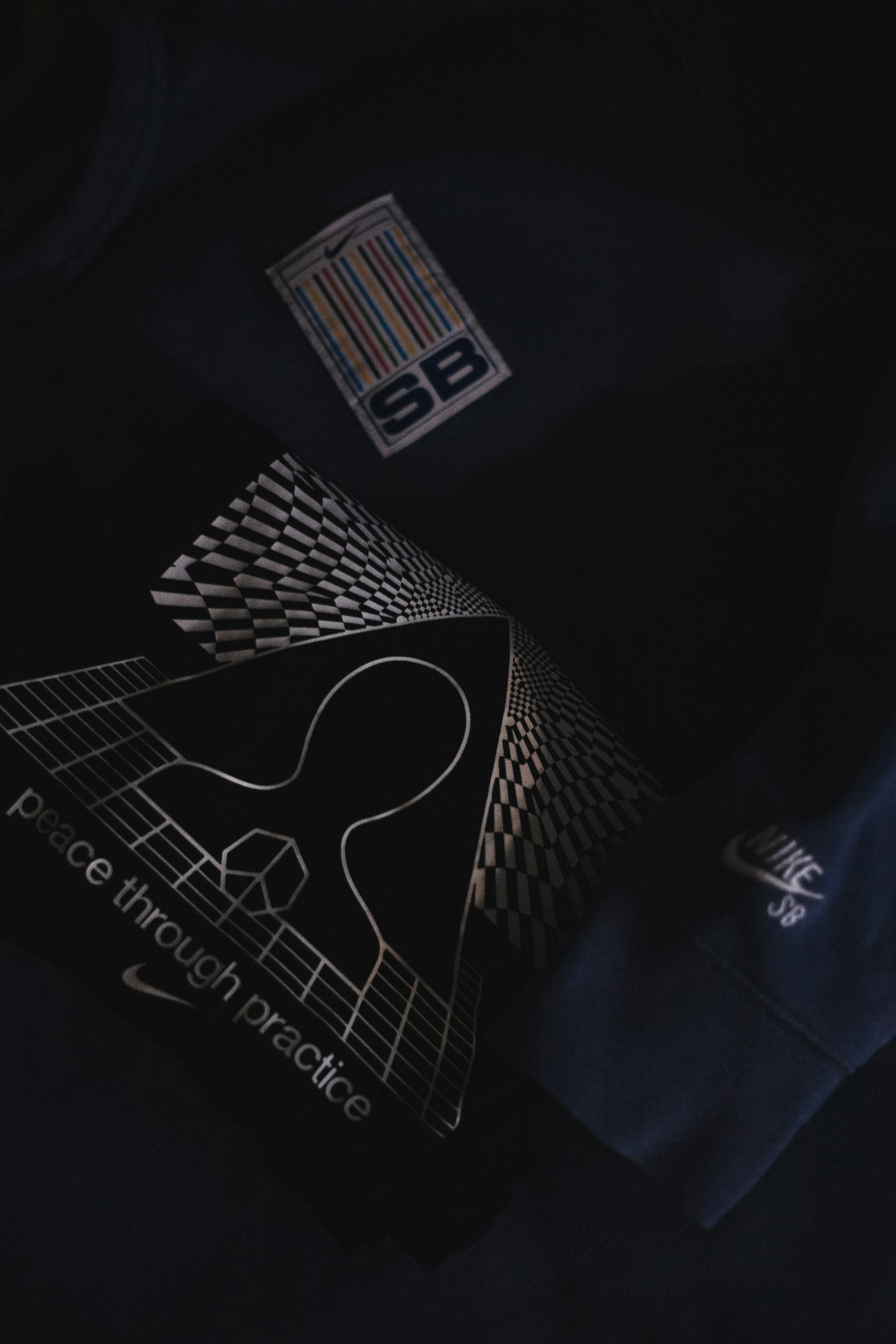 Noir Nike SB Patch Meets Geometric Card in Dim Ambient Light