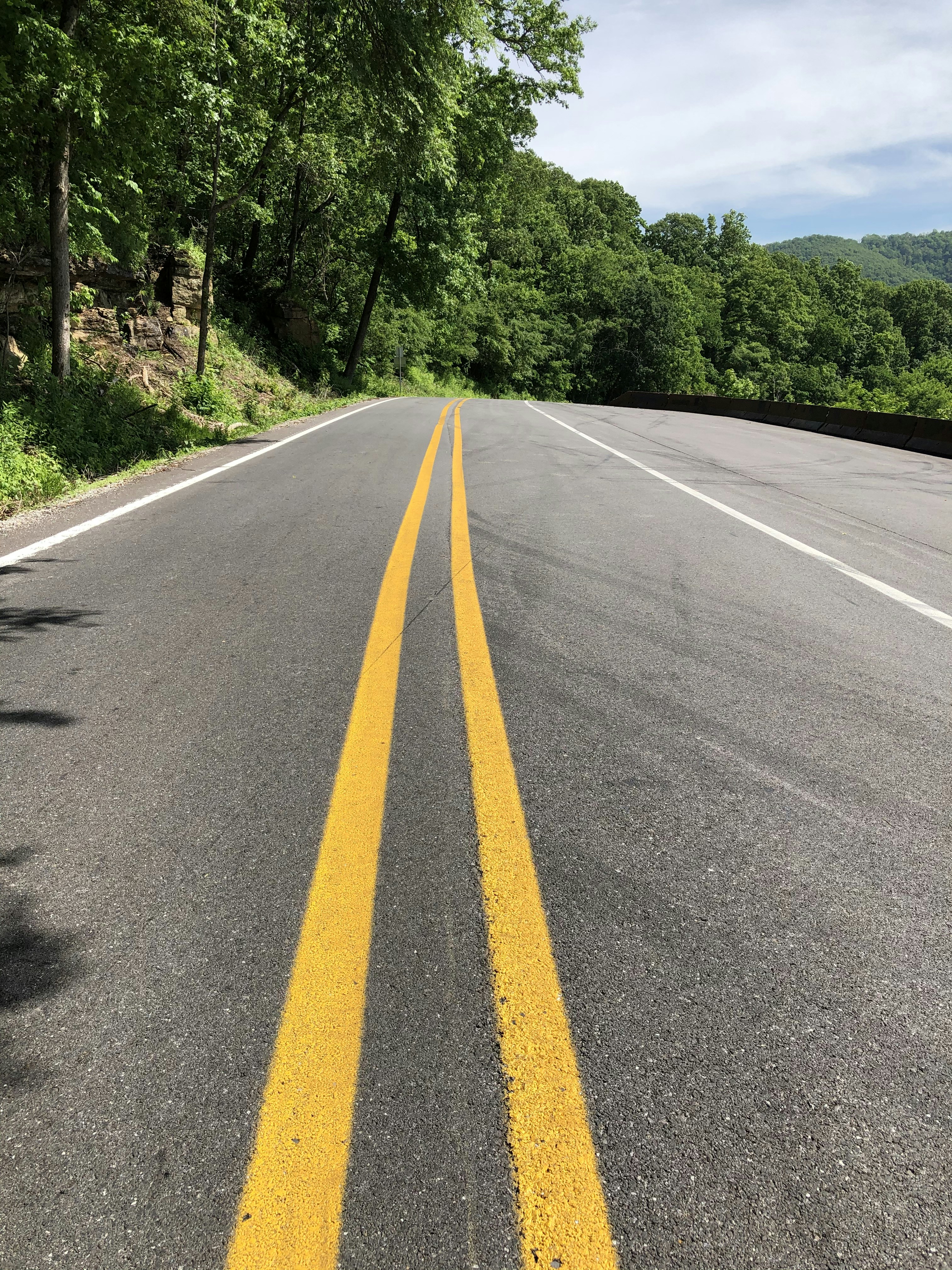 A road with a yellow line on the side of it photo – Free Road Image on ...