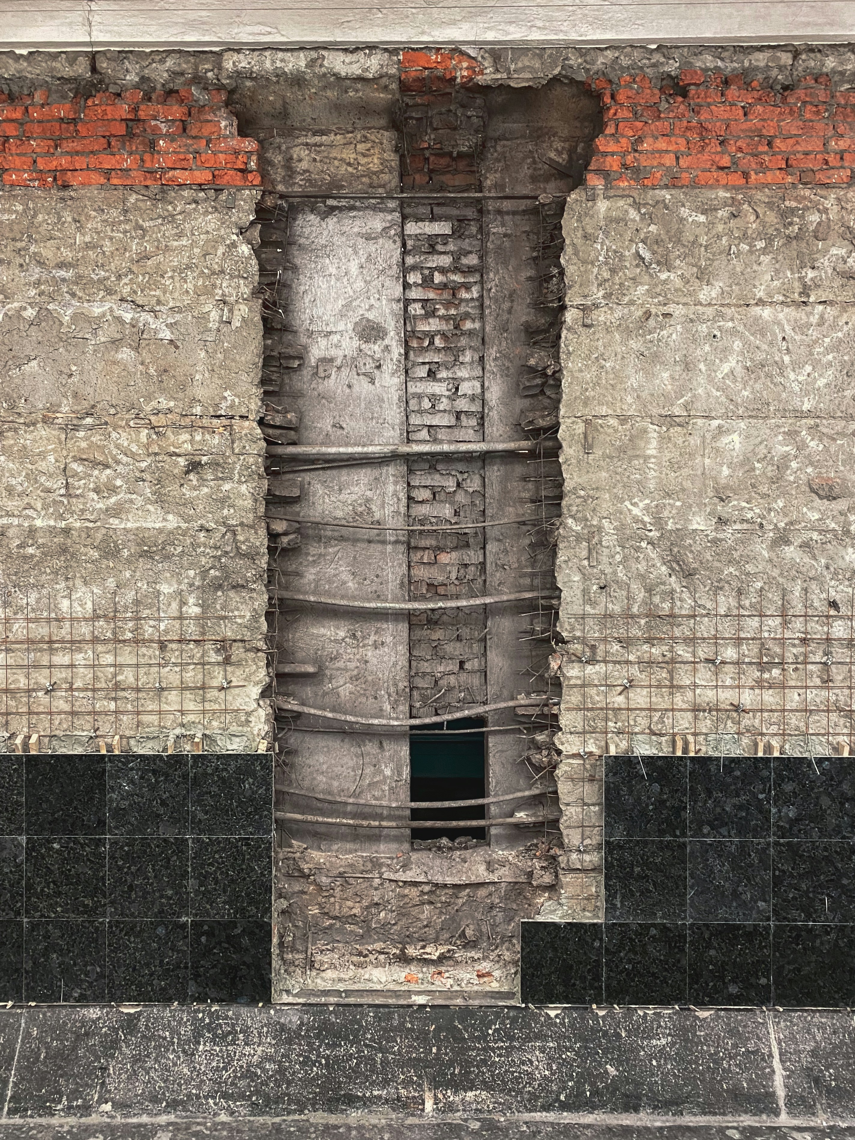 Narrow Brick Shaft Framed by a Weathered Facade