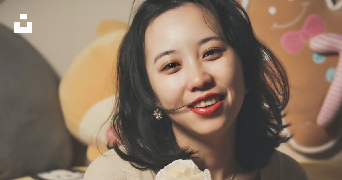 그녀의 손에 꽃을 들고 소파에 앉아있는 여자 사진 Unsplash의 무료 중국 이미지