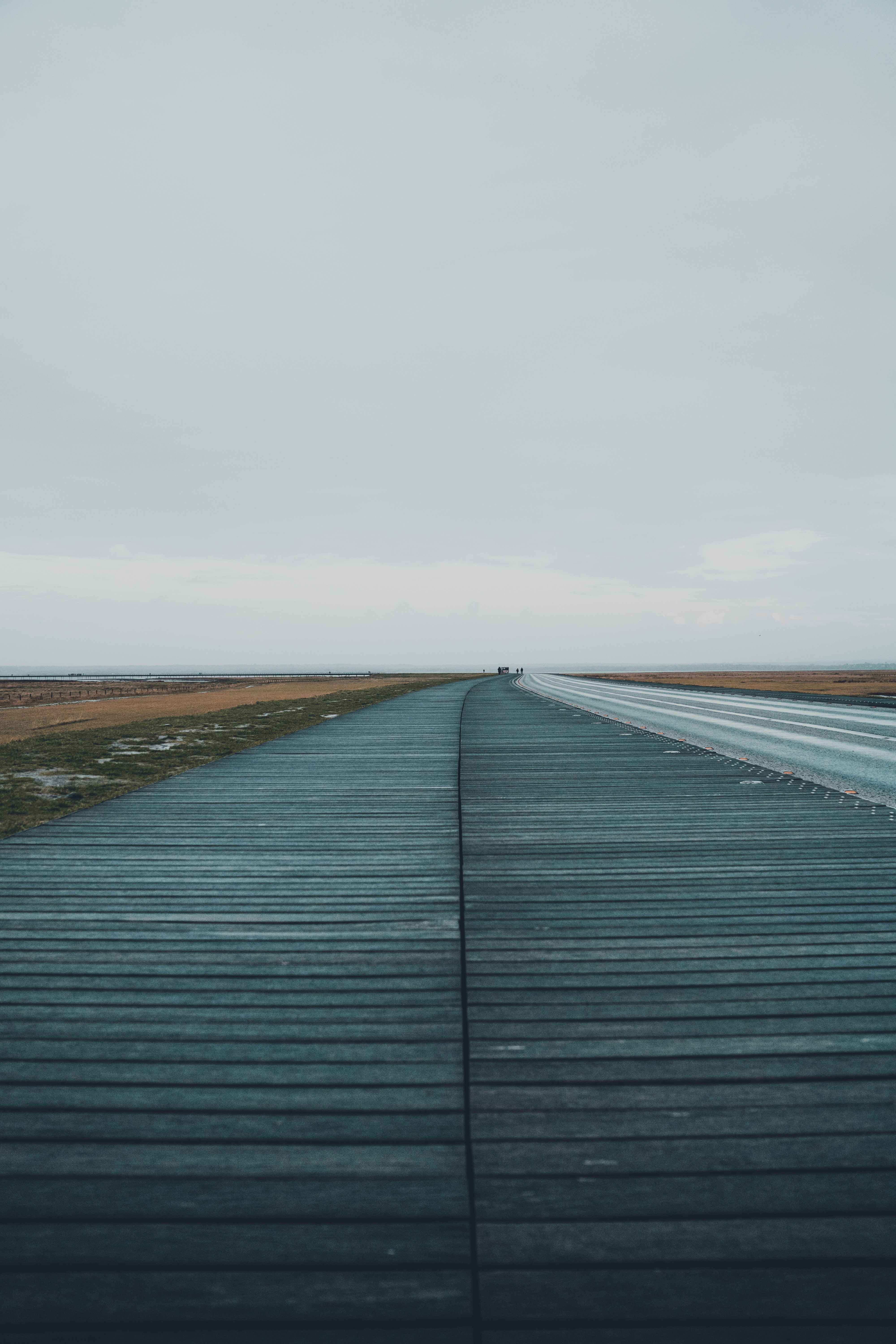 a long straight road with a sky in the background