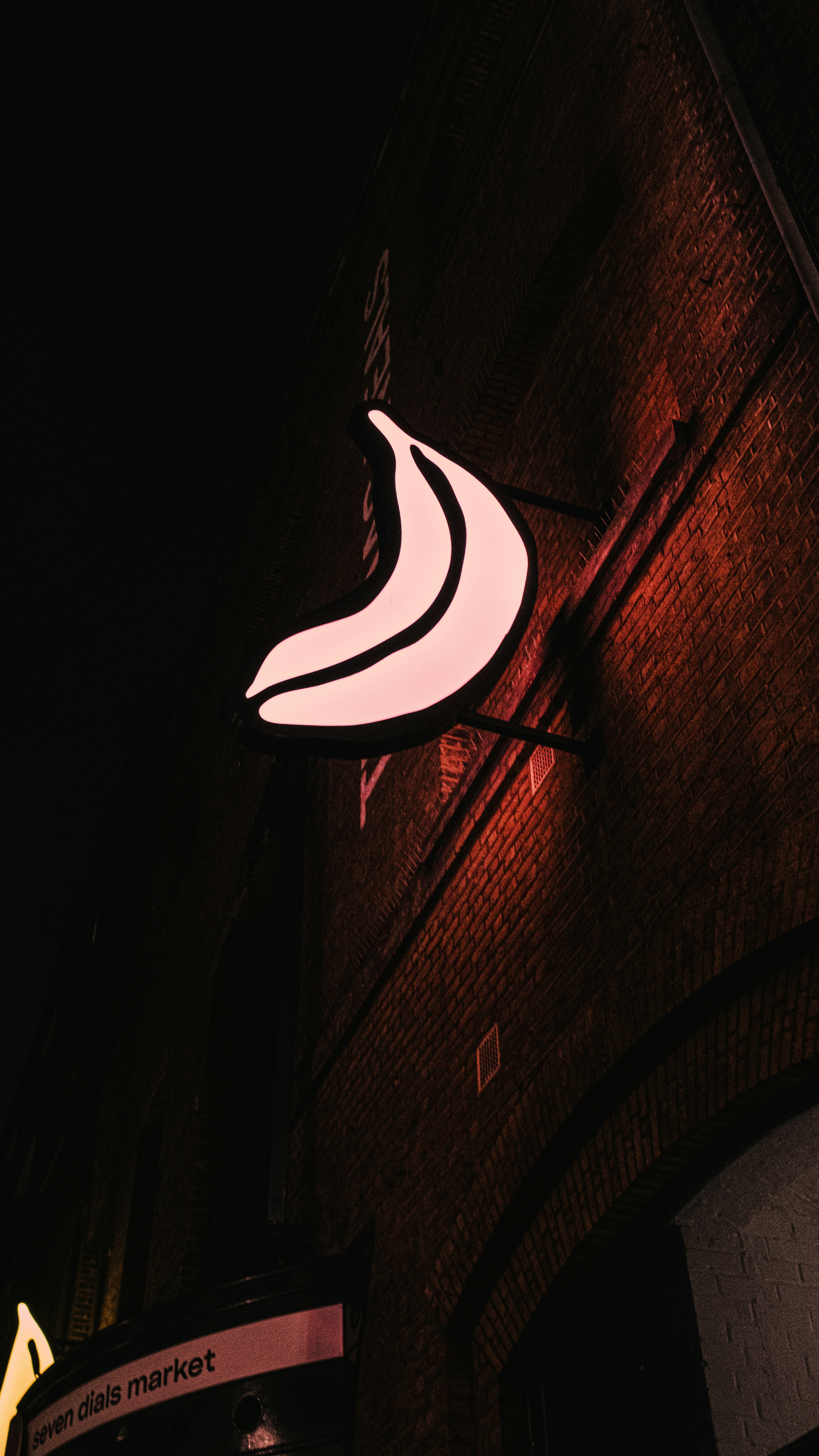 a sign on the side of a building lit up at night