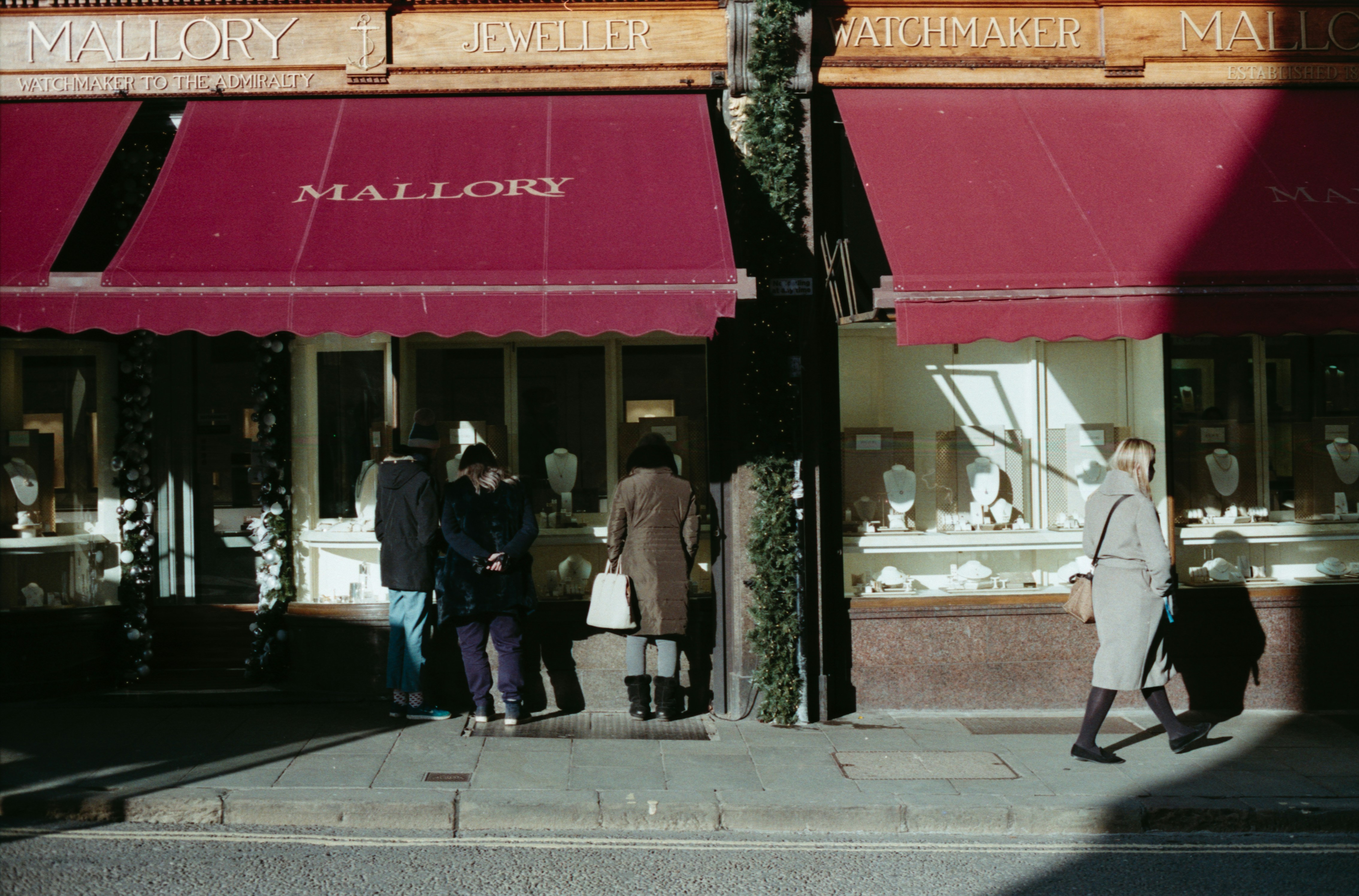 A group of people standing outside of a store photo – Free Uk Image on ...
