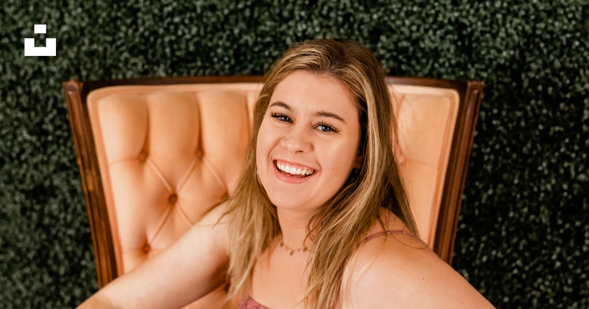 Une Femme Assise Sur Une Chaise Avec Un Sourire Sur Son Visage Photo