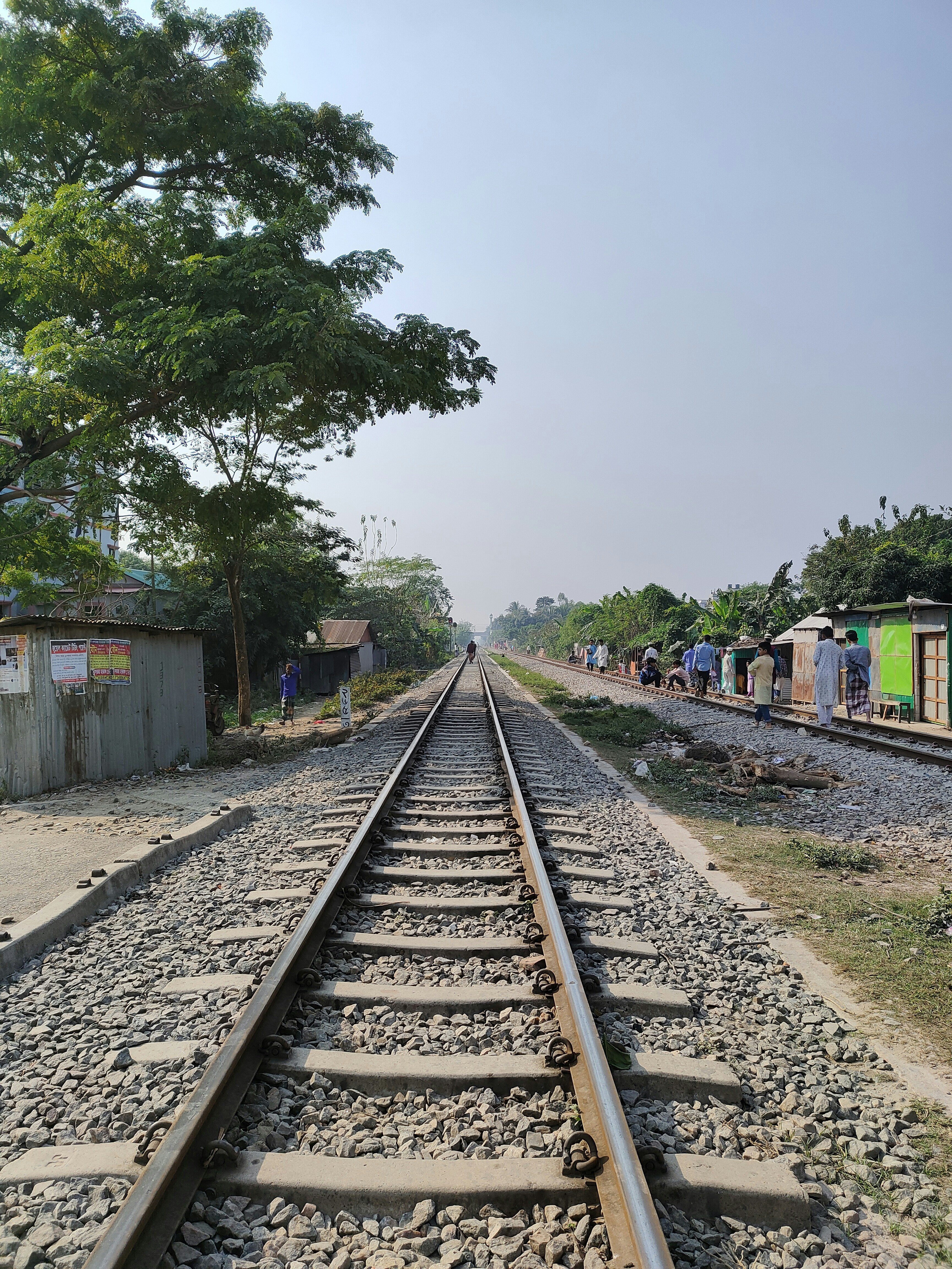 a train track with people standing on the side of it