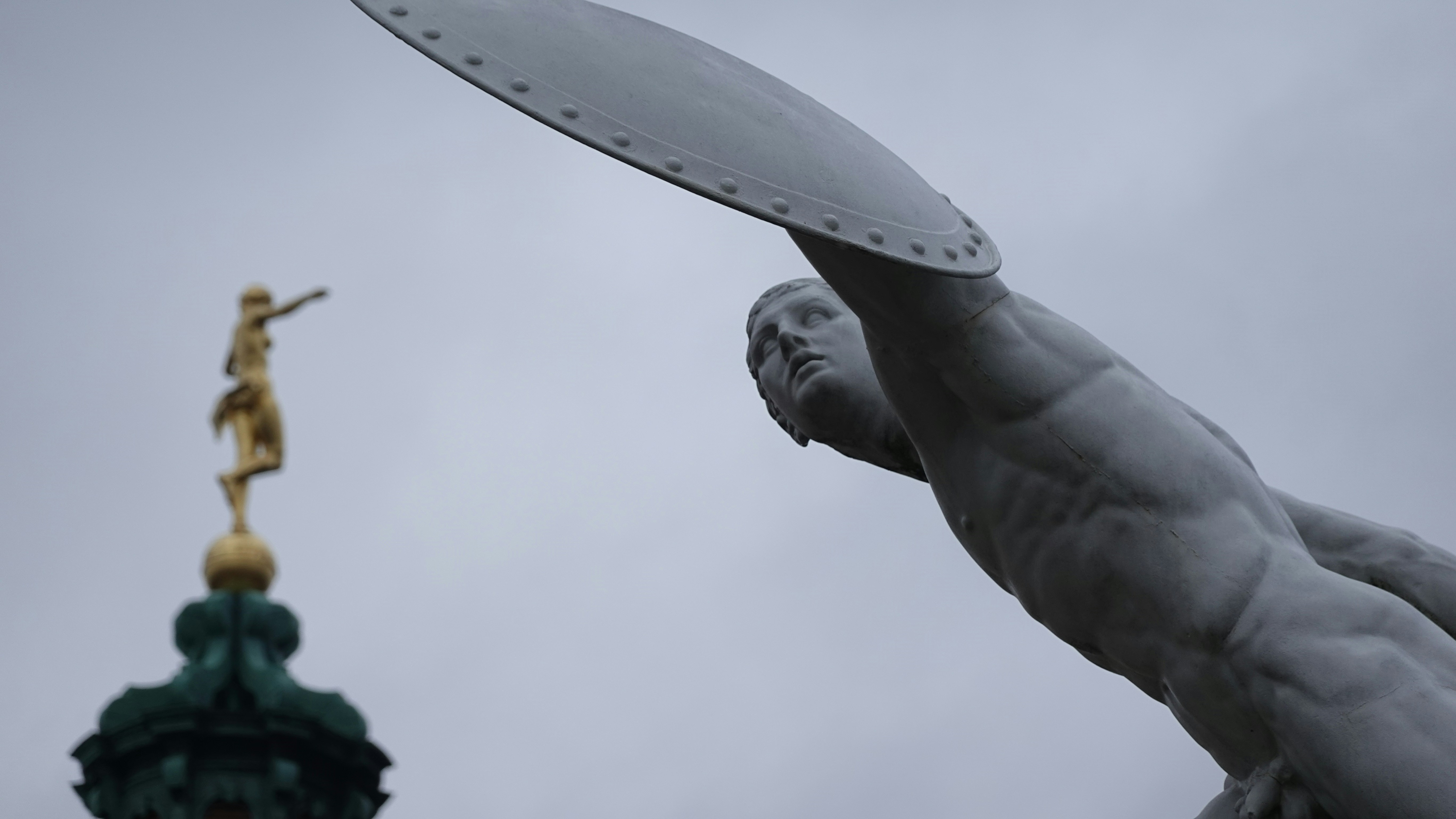 Leaning Colossus Under a Skyward Disk