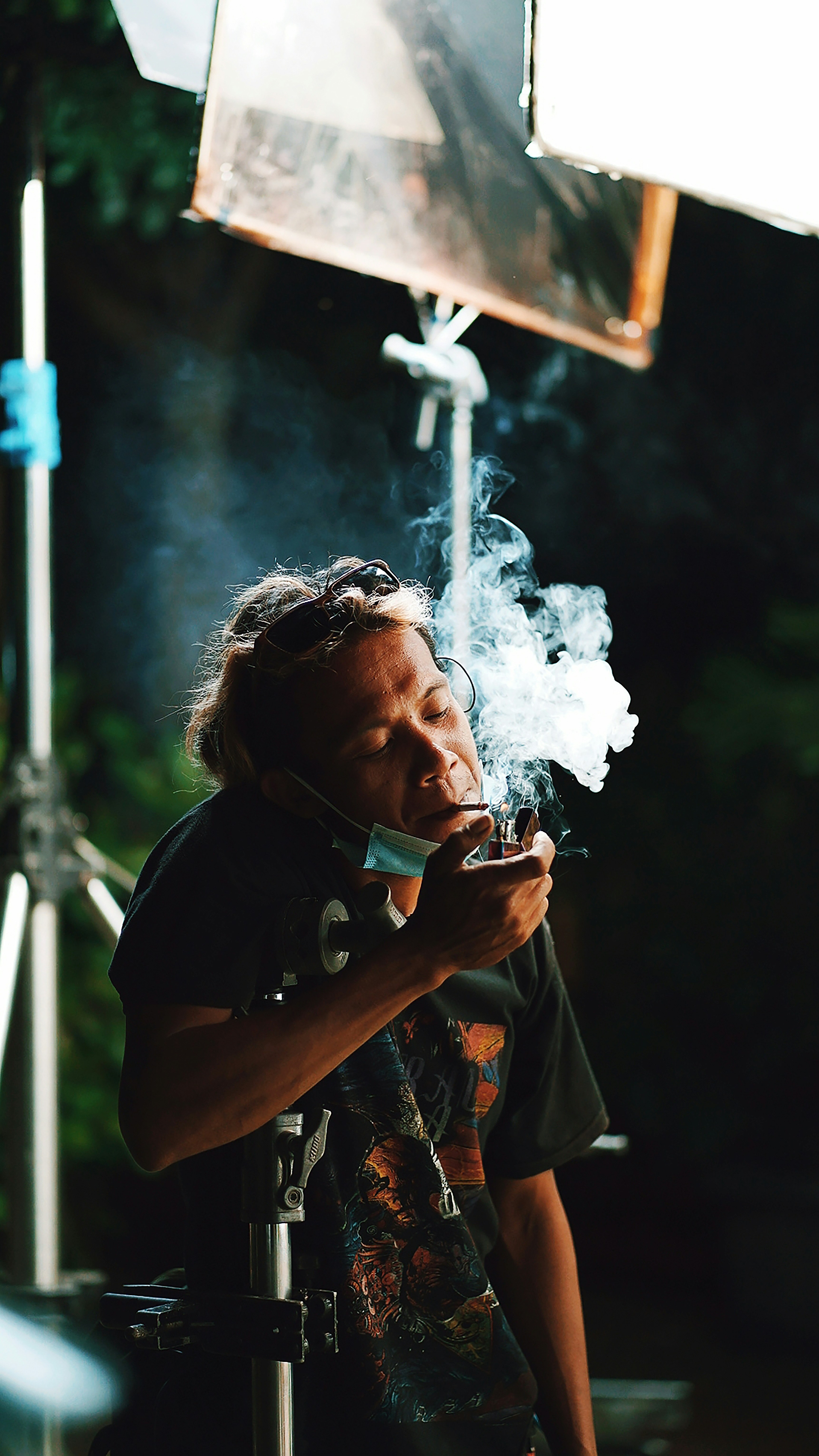 A man smoking a cigarette in front of a camera photo – Free Person ...
