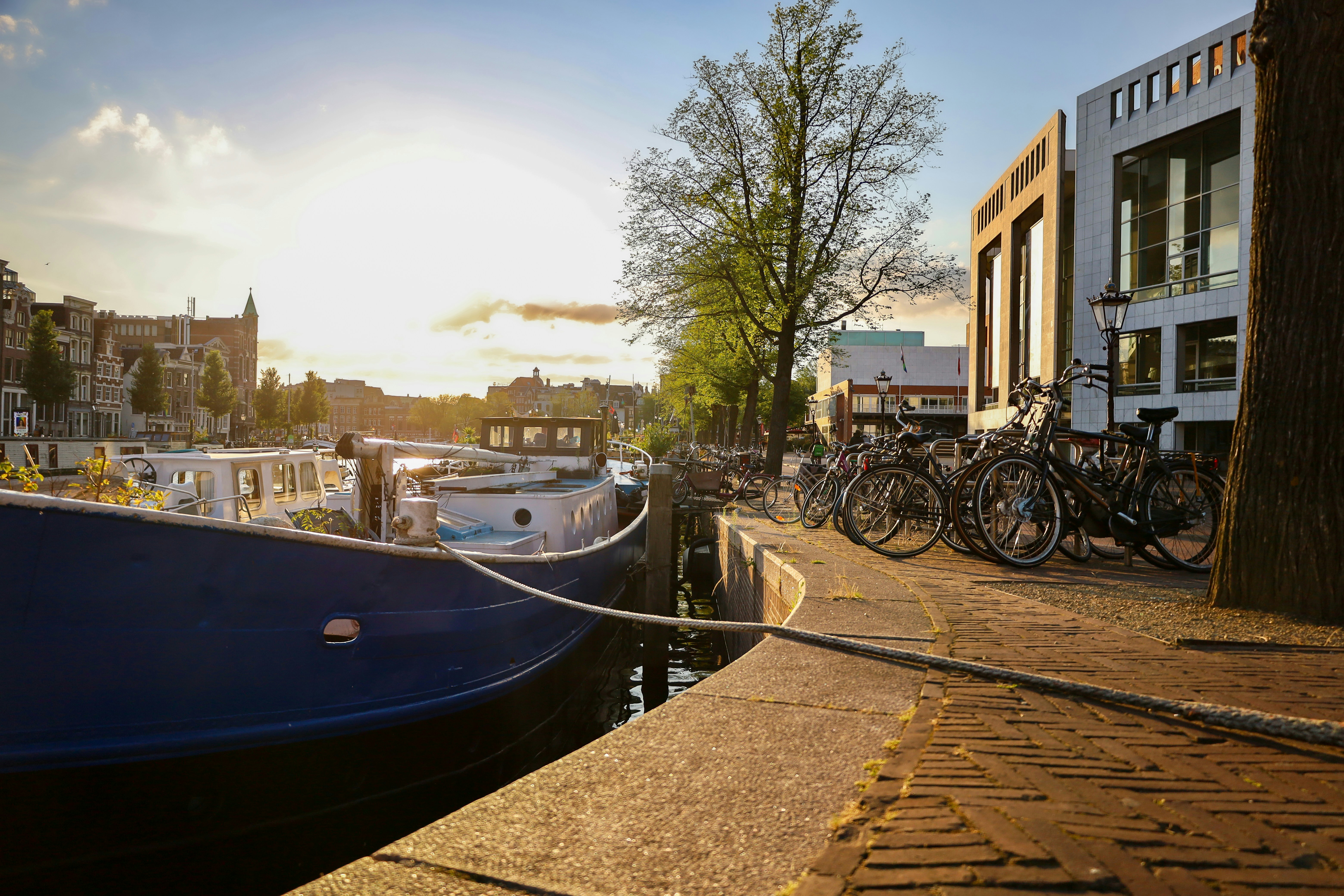 Blue Hull at Dusk: A Quiet Canal Edge Framed by Bikes and Modern Facades