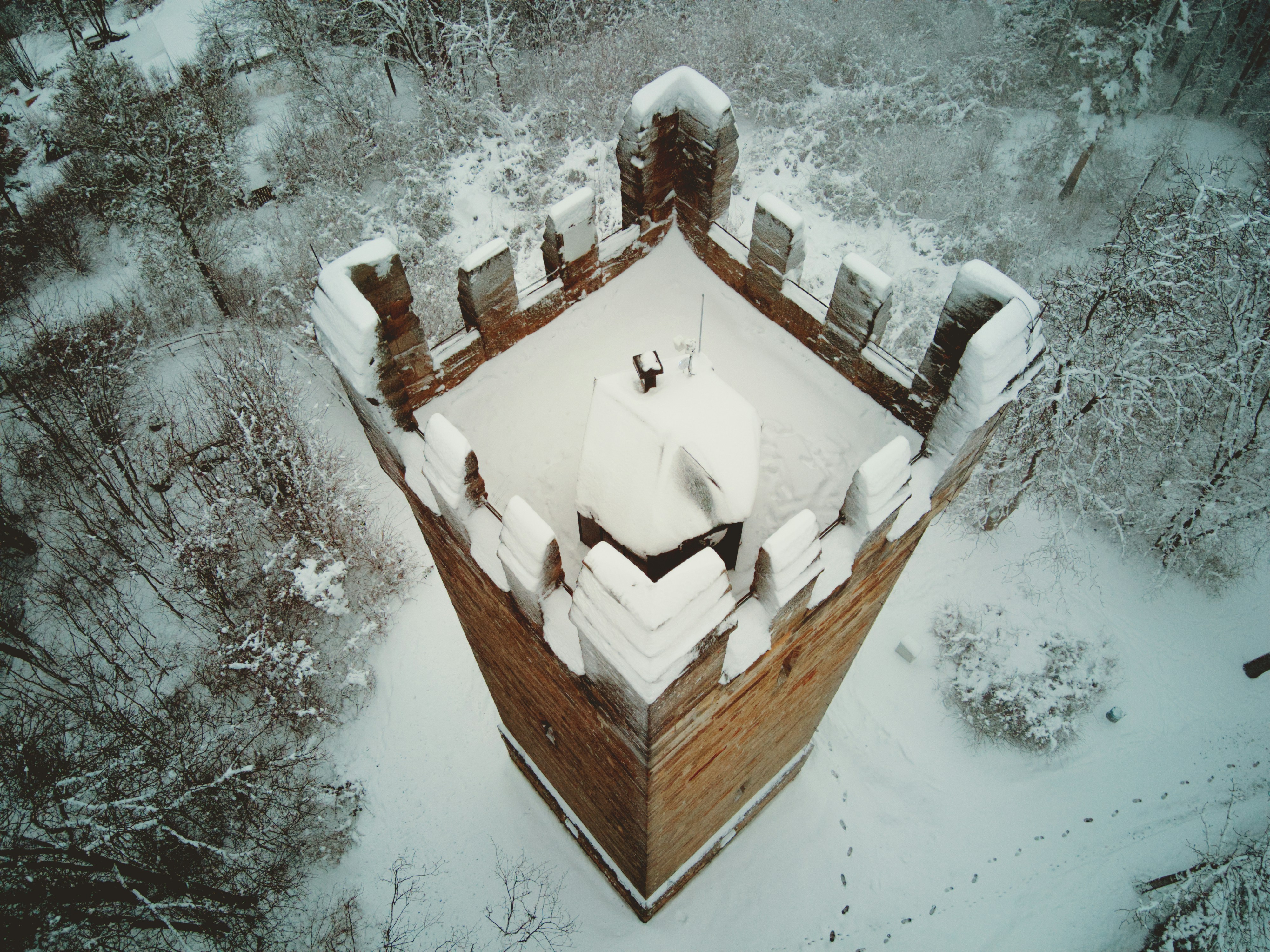 an aerial view of a tower in the snow