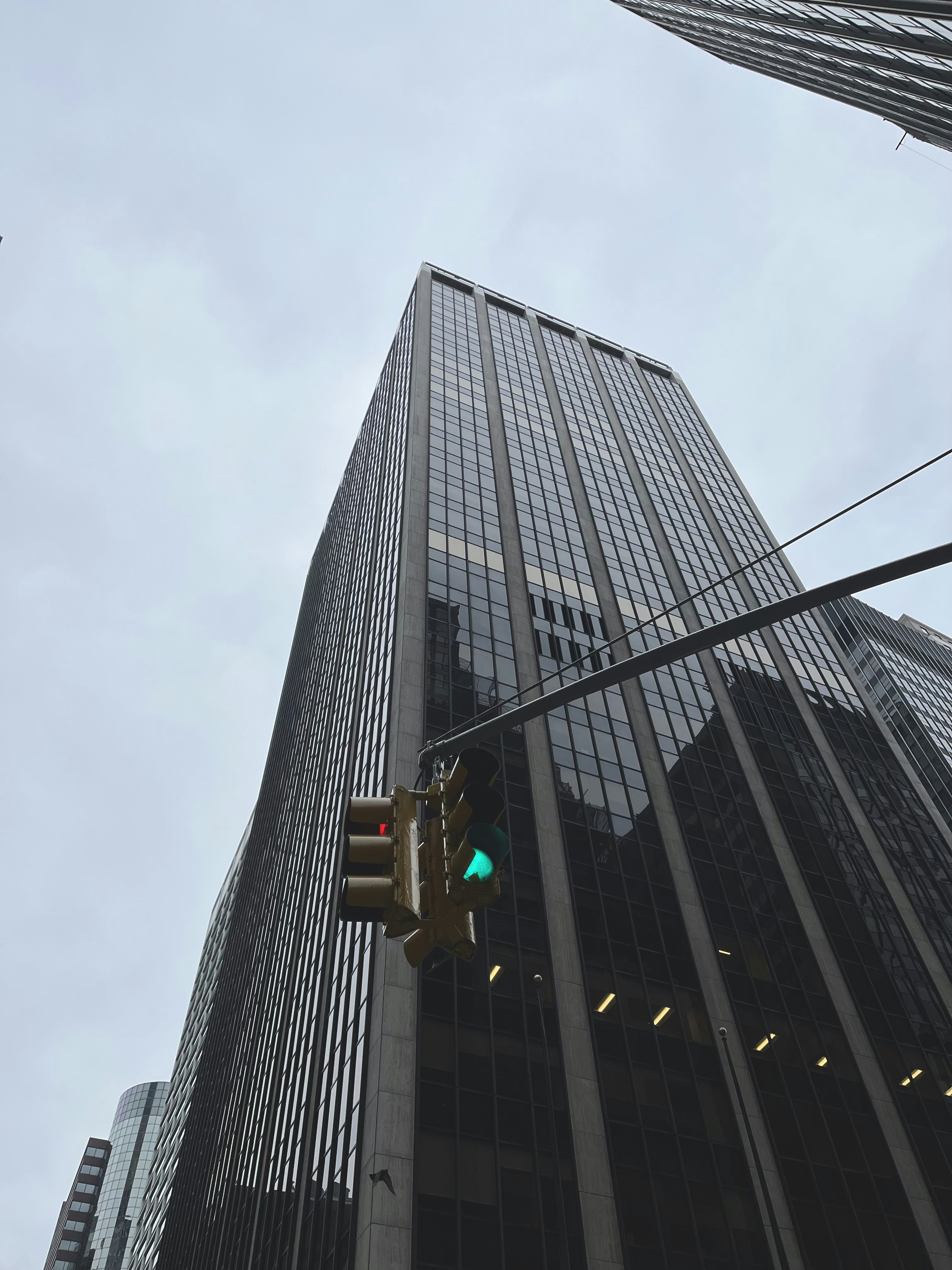 A traffic light hanging from the side of a tall building photo – Free ...