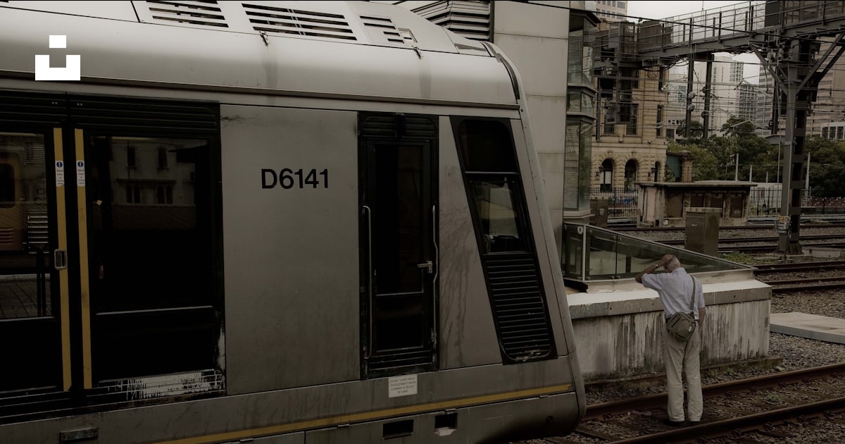Un Homme Debout à Côté Dun Train Sur Une Voie Ferrée Photo Photo