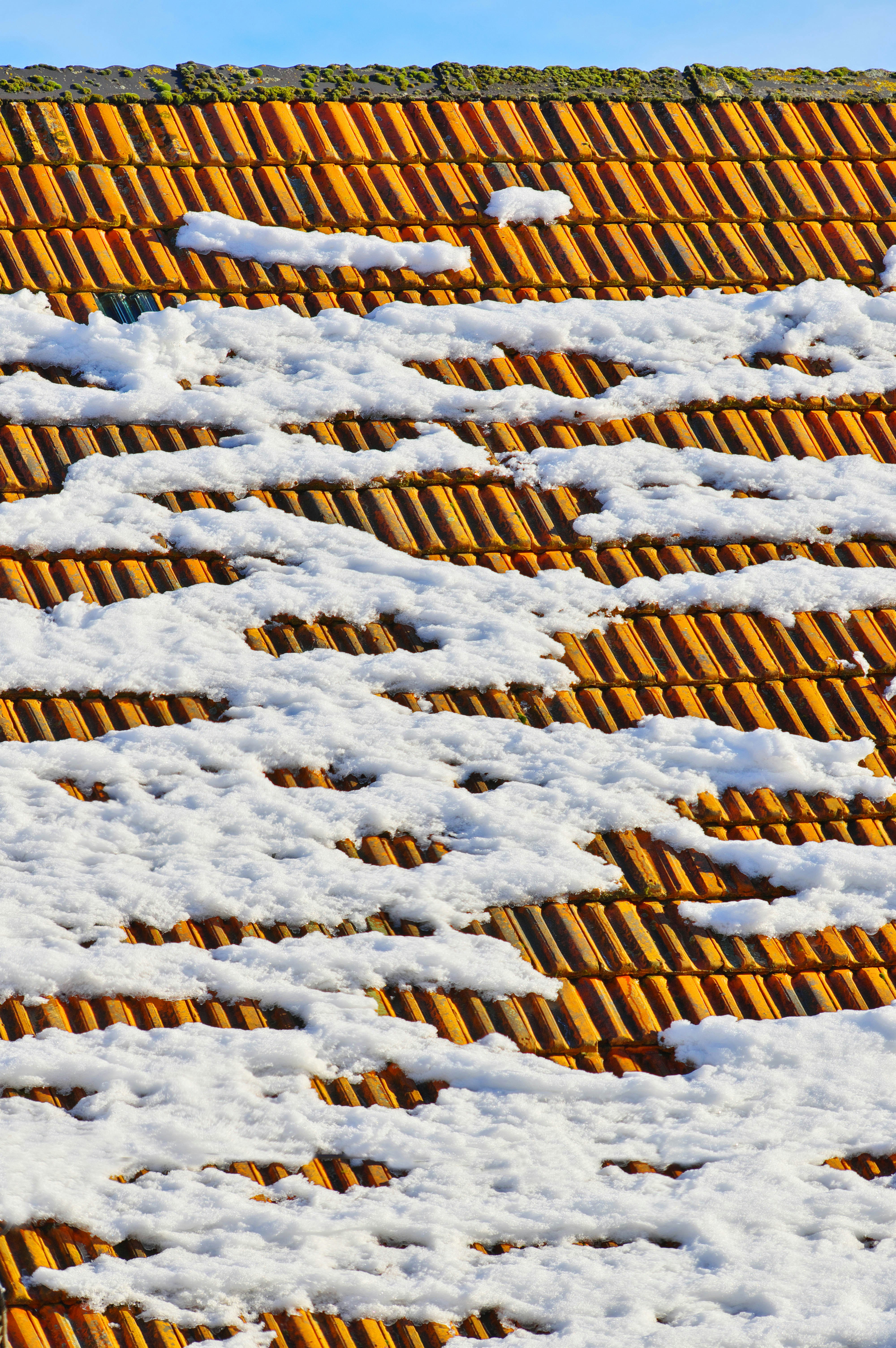 Sunlit diagonals: snow-dusted terracotta roof