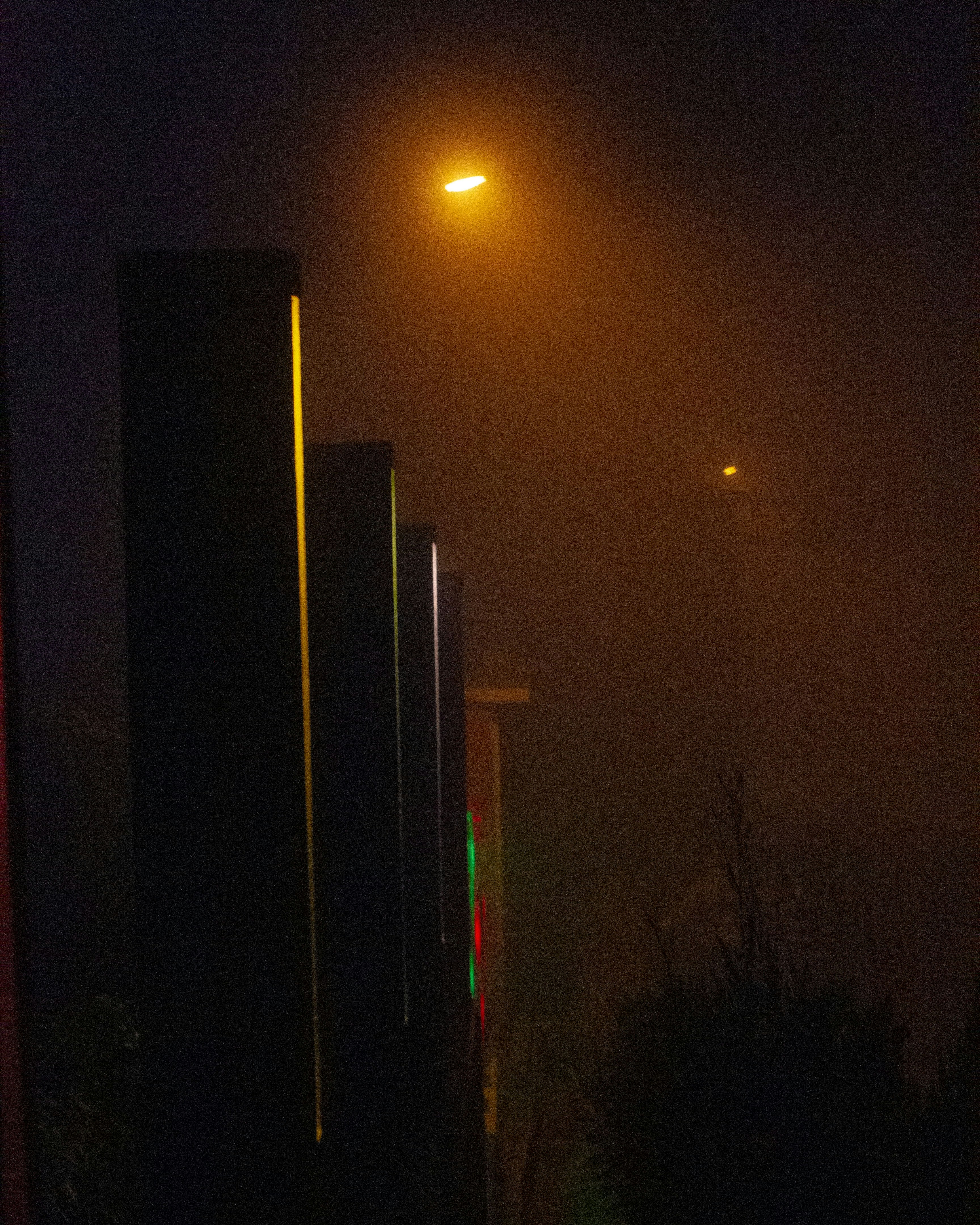 a street light shines brightly in the dark
