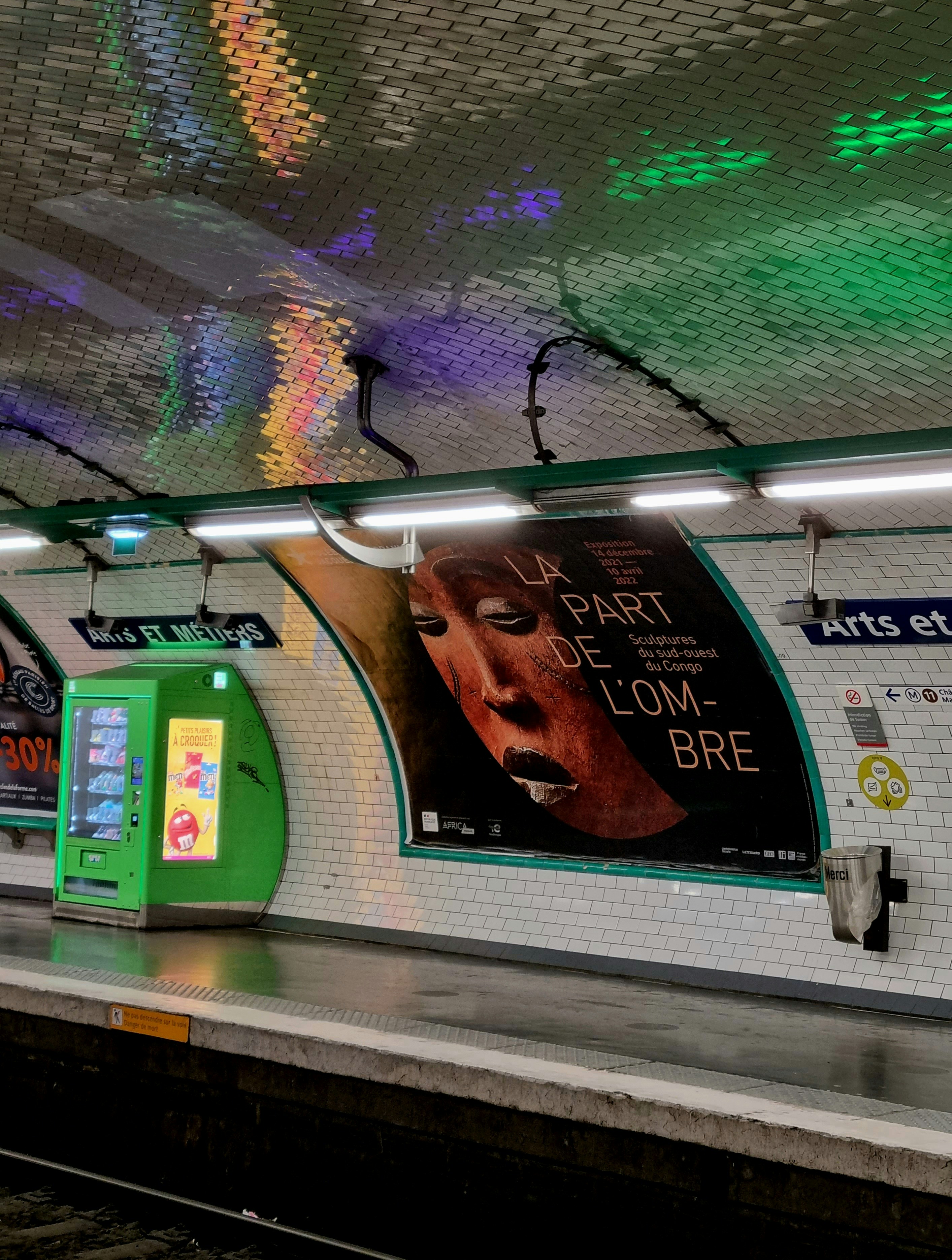 A subway station with a poster on the wall photo – Free Paris Image on ...