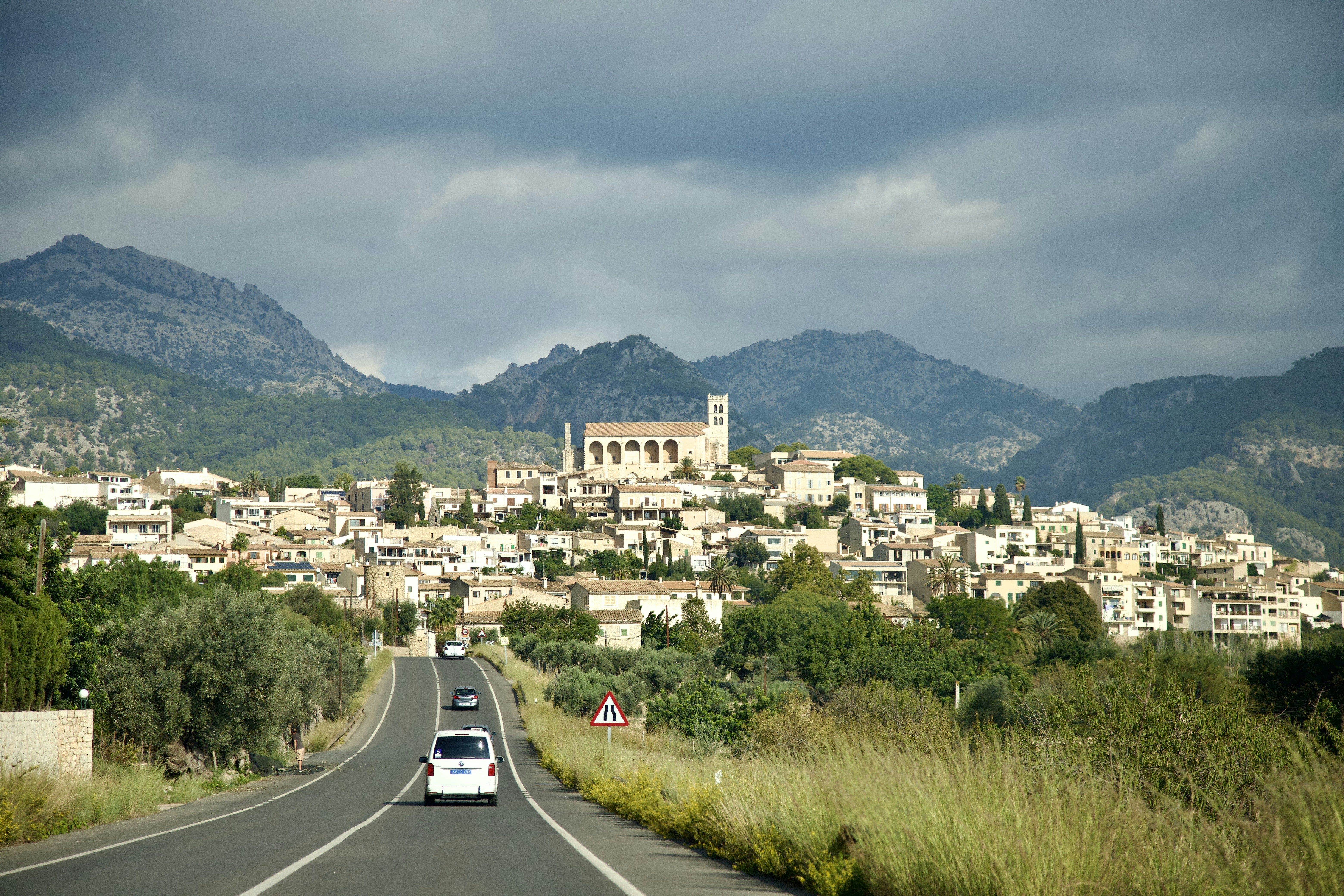 a car driving down a road with a city in the background