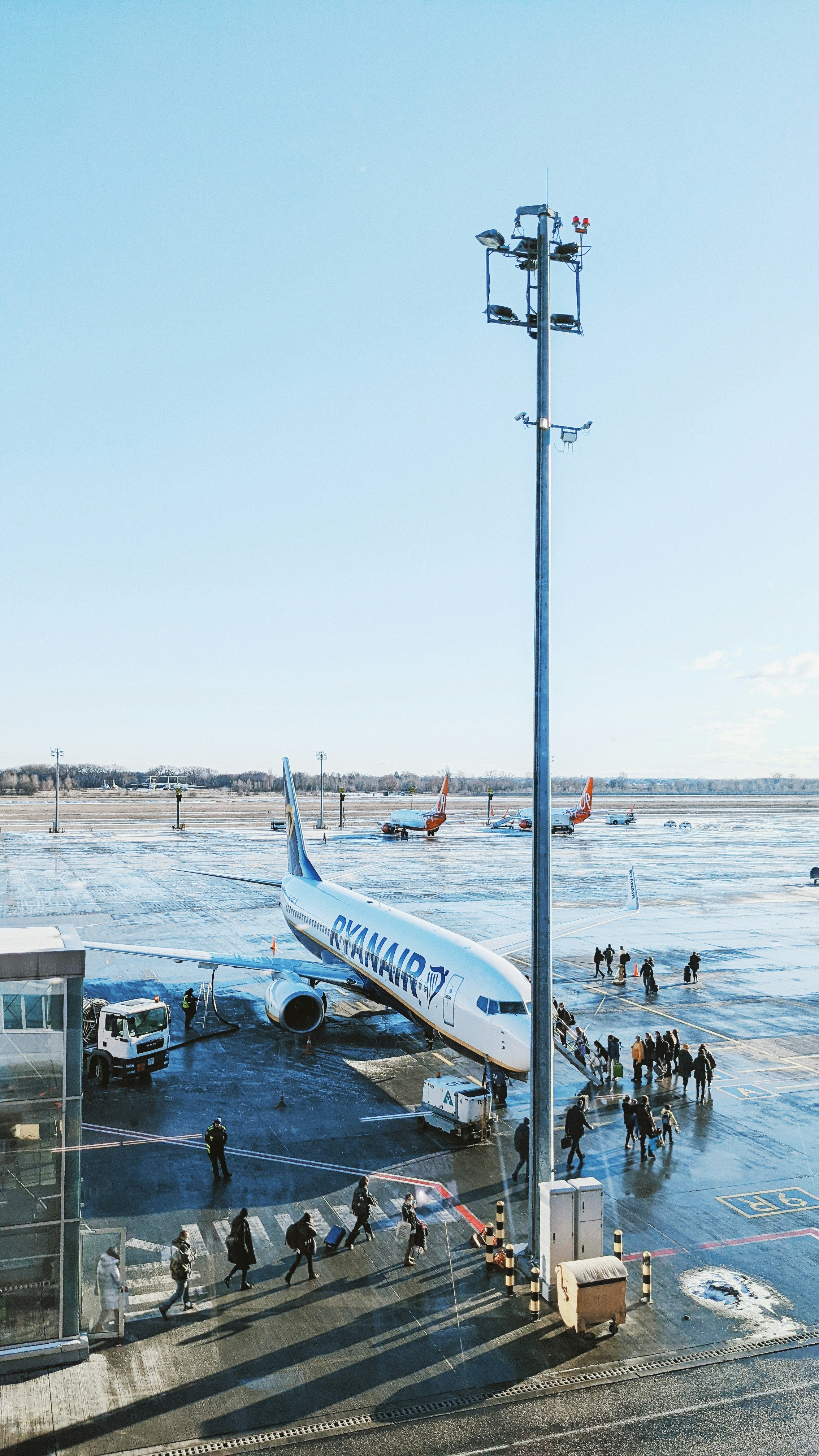 Ryanair at Gate: Sunlit Boarding Beneath a Towering Airport Light