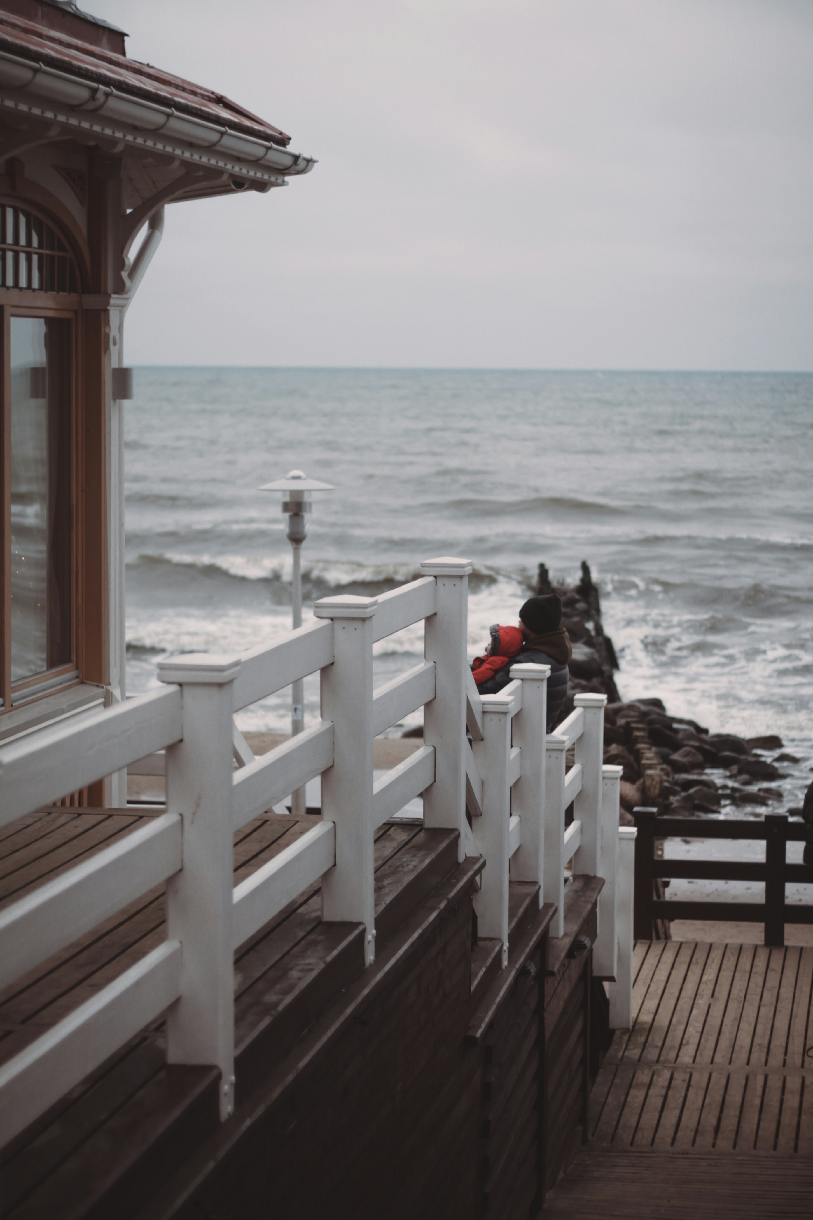 Red Coat at the Pier's Edge: A Quiet Encounter with the Sea
