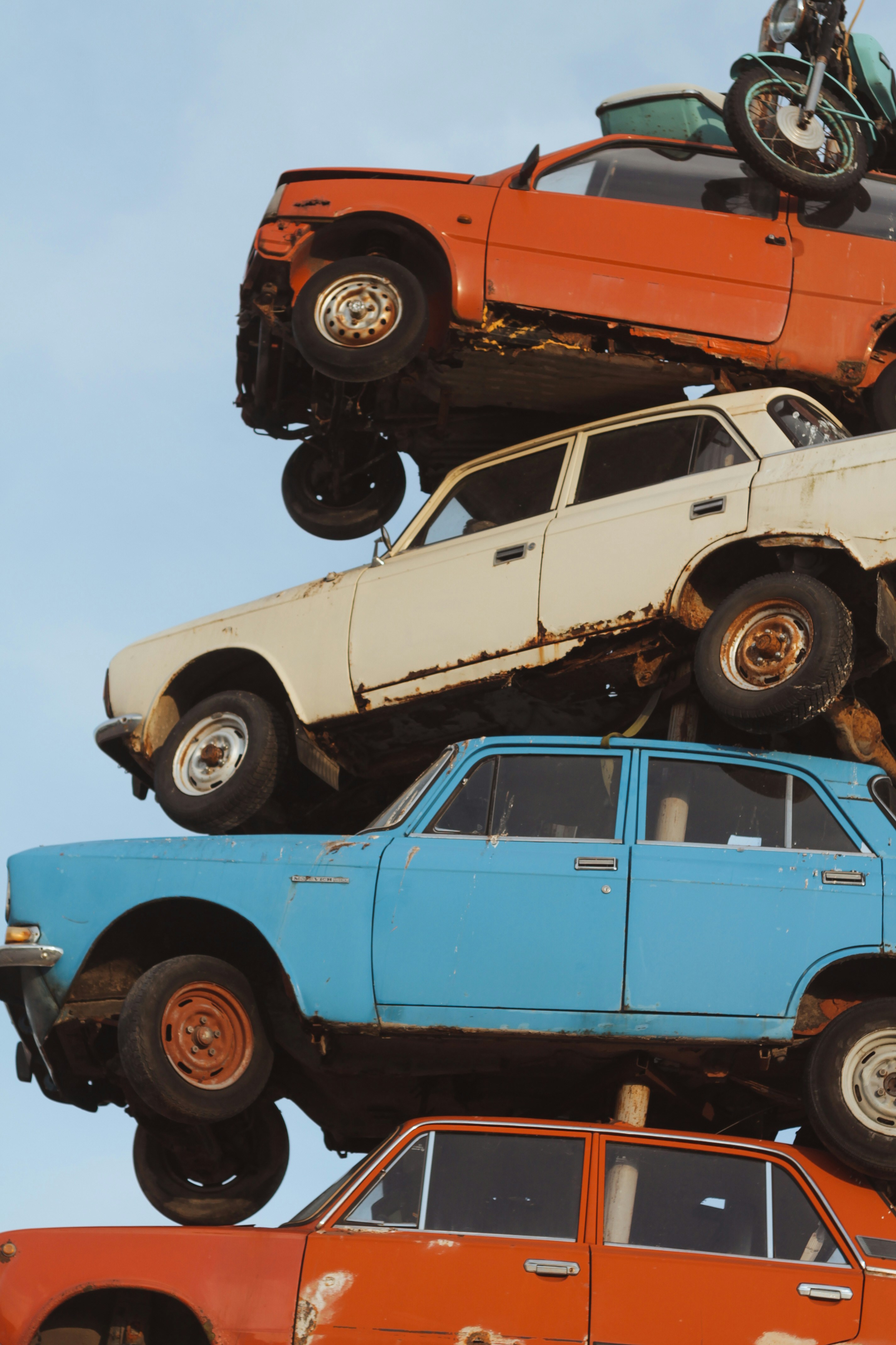 Stacked relics: a vertical stack of vintage cars waiting for gravity