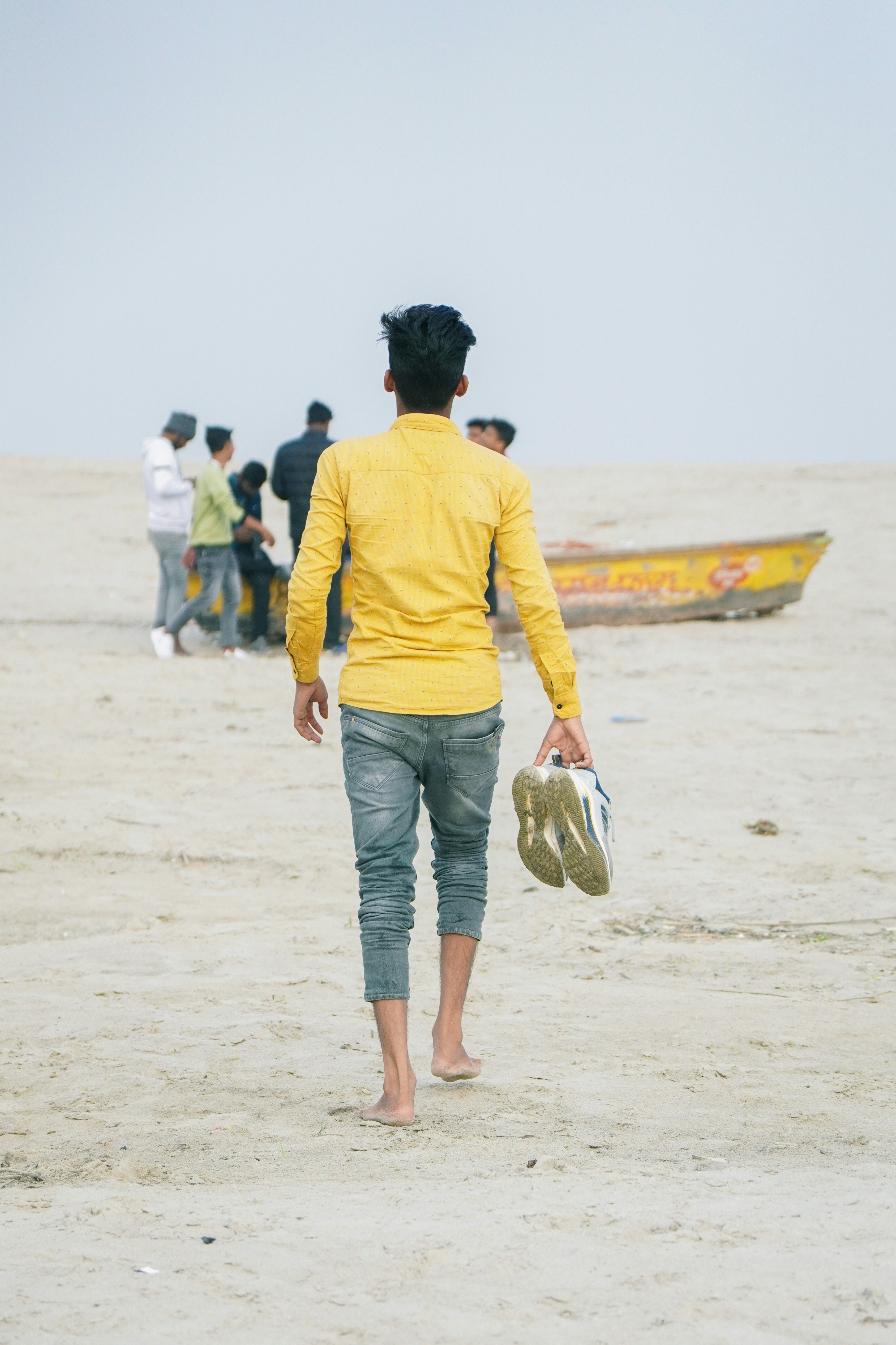 Barefoot Departure: A Yellow-Shirted Figure Heads Toward the Horizon
