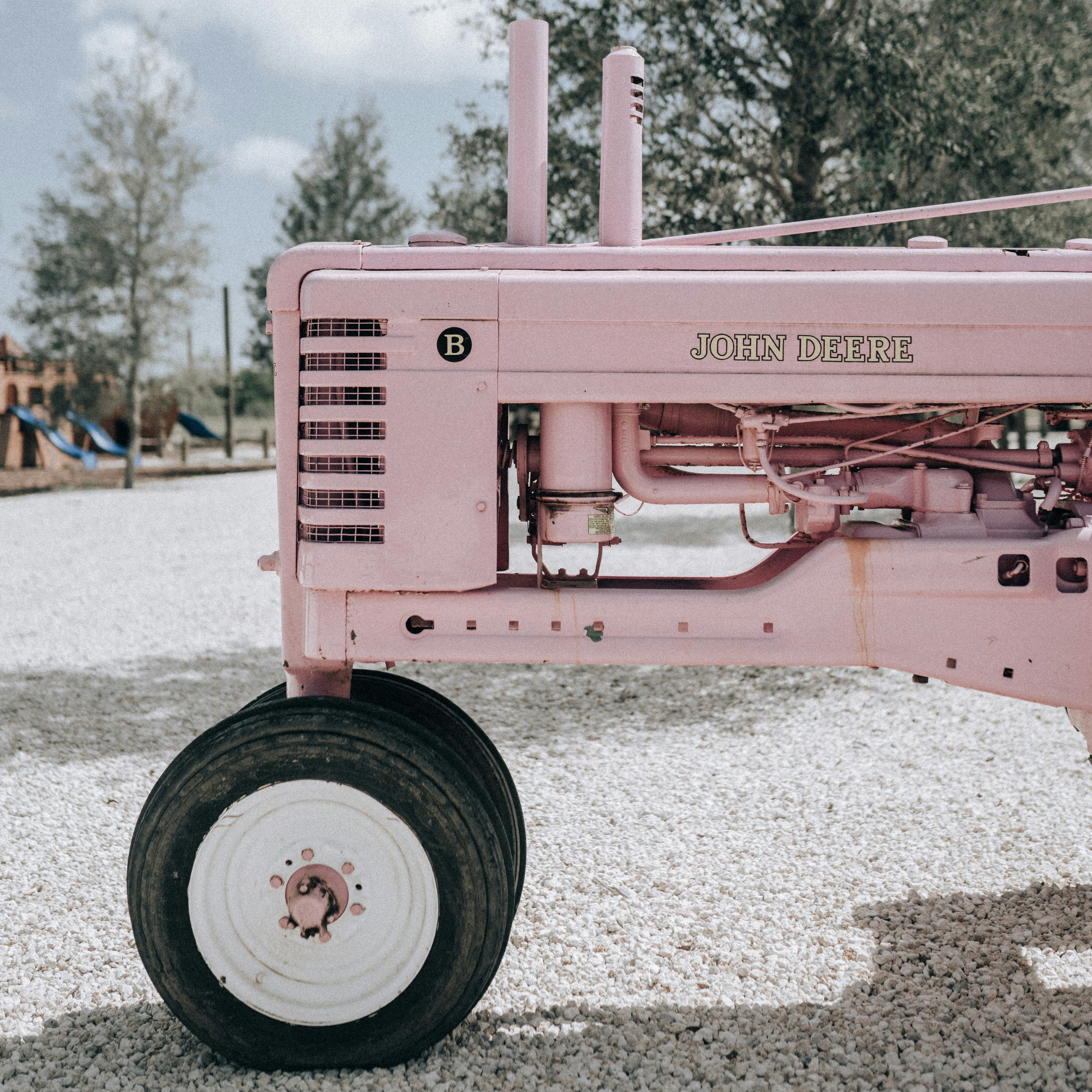 Foto Un tractor rosa estacionado en un lote de grava – Imagen El verano ...