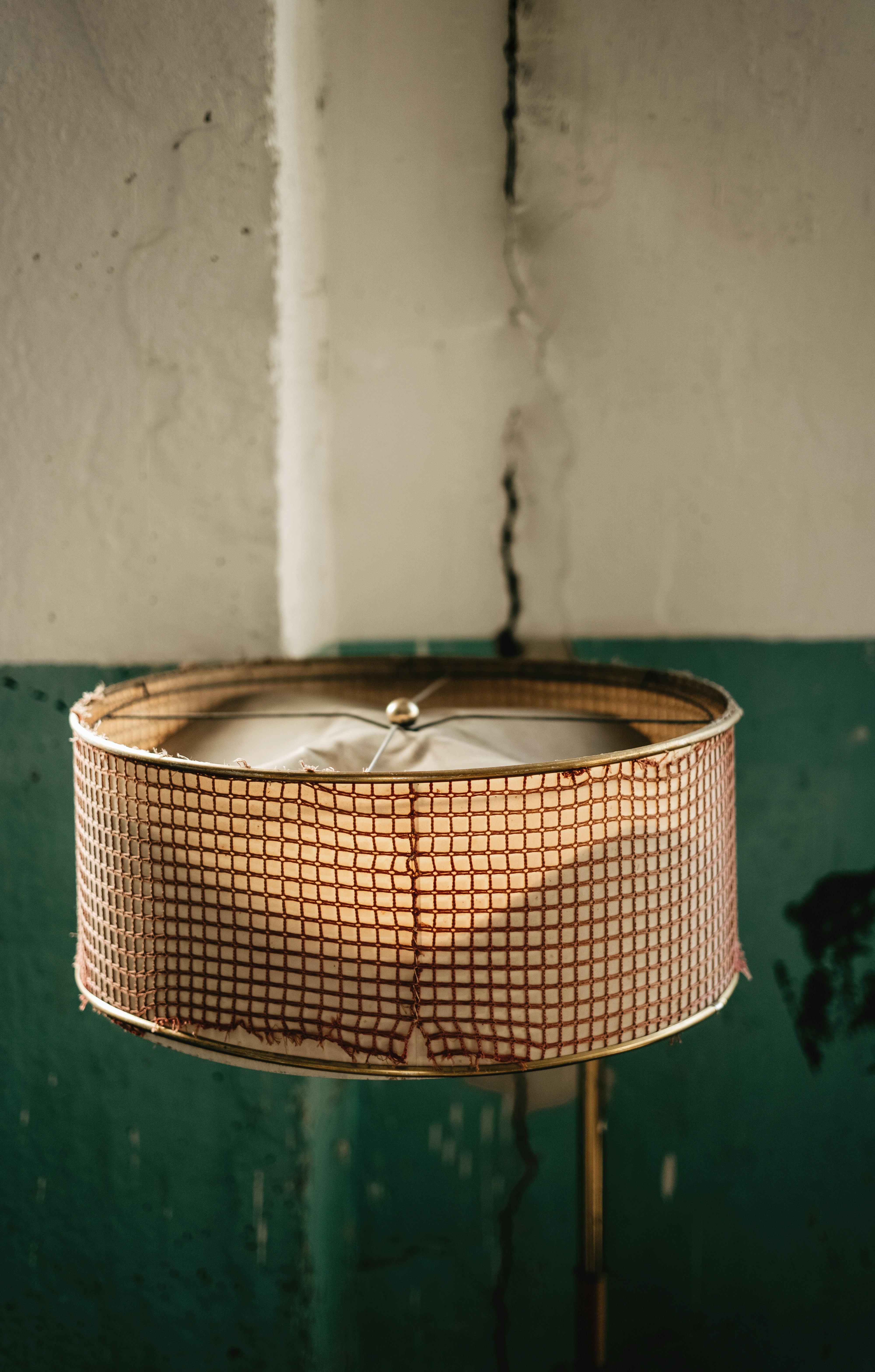 Dim Lamp, Rusty Mesh: A Quiet Corner with a Hanging Shade