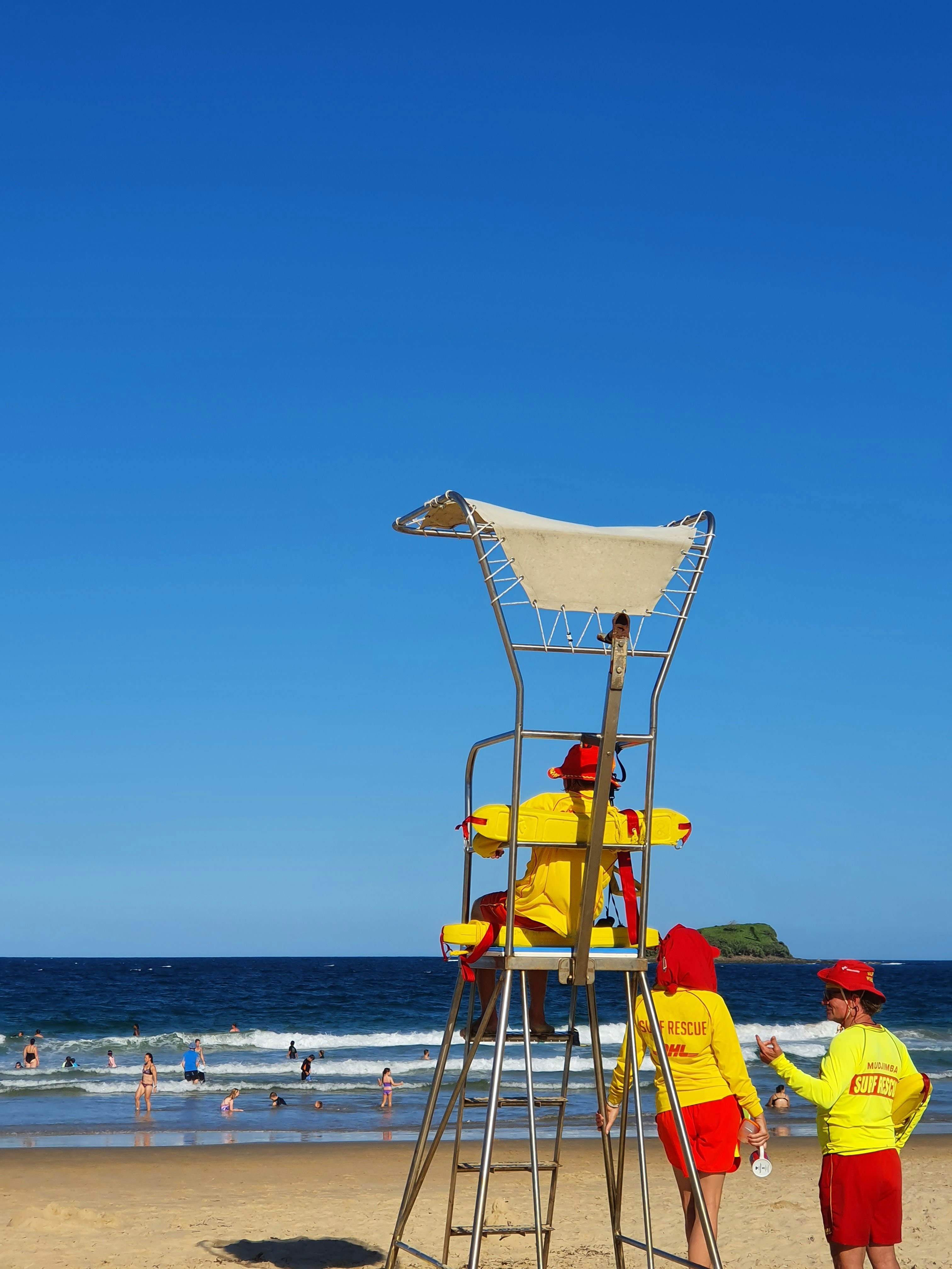 Azure Sky Watch: Lifeguard Tower Anchored on the Sunlit Shore