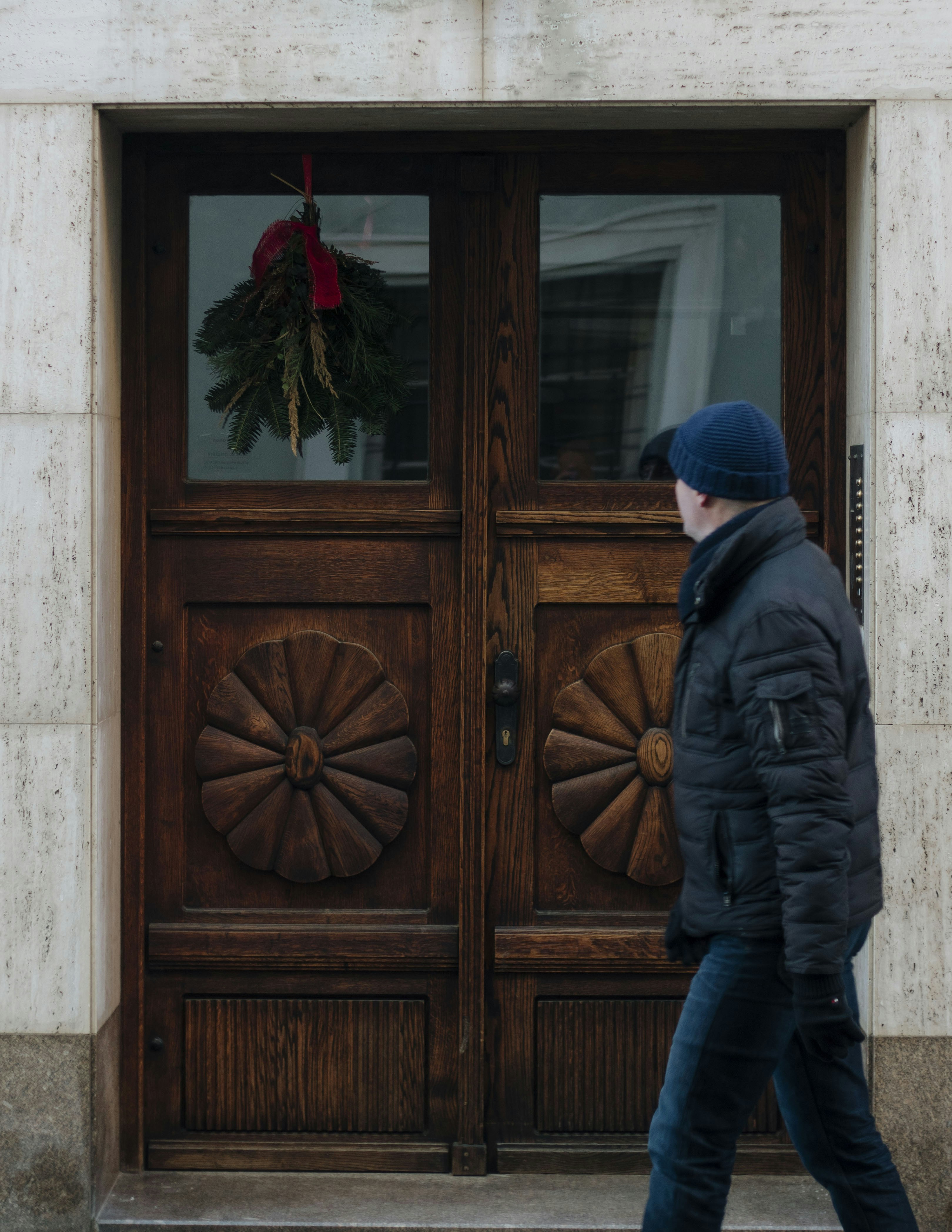 Un homme passant devant une grande porte en bois photo – Photo Praga ...