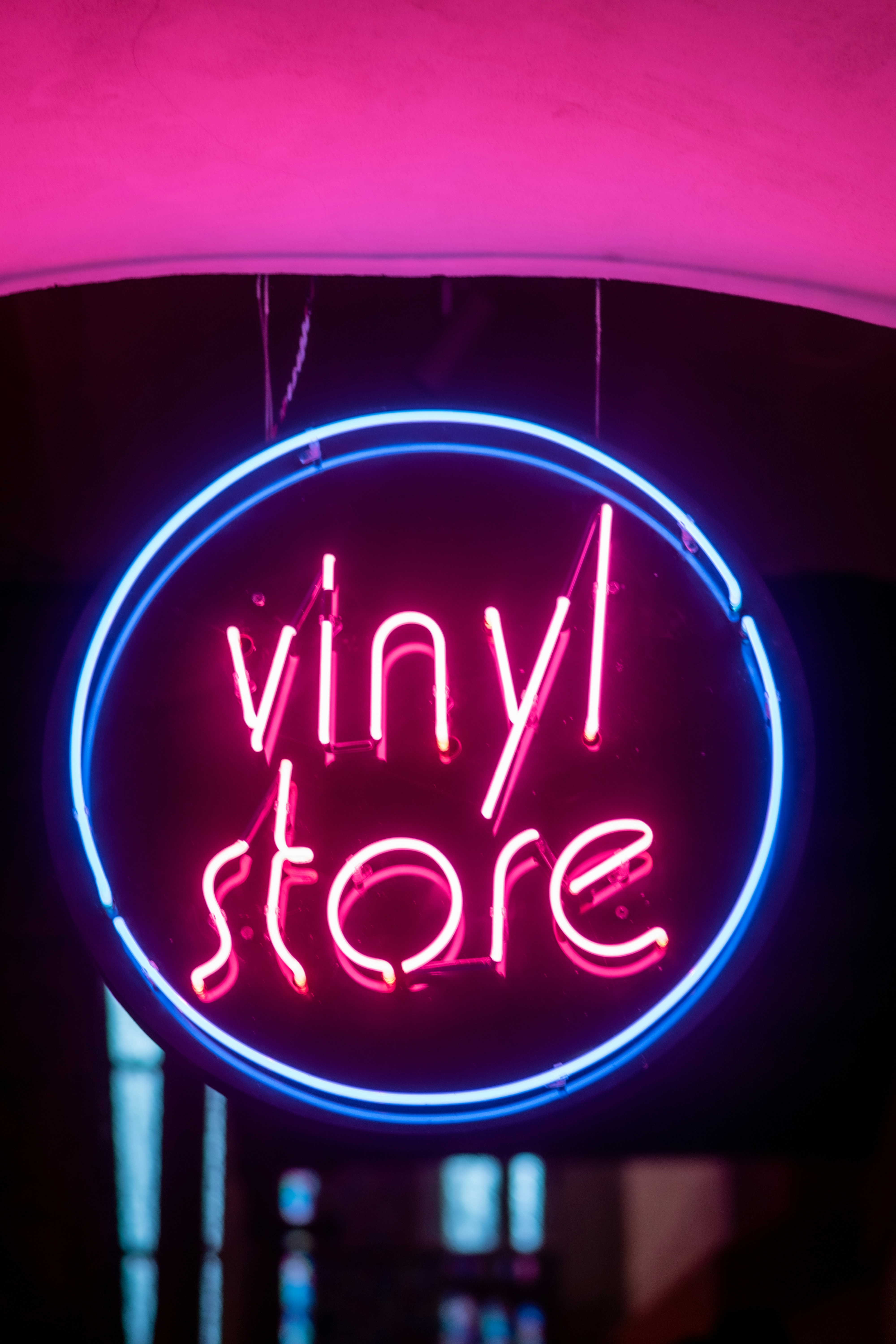 A neon sign hanging from the ceiling of a store photo – Free Light ...