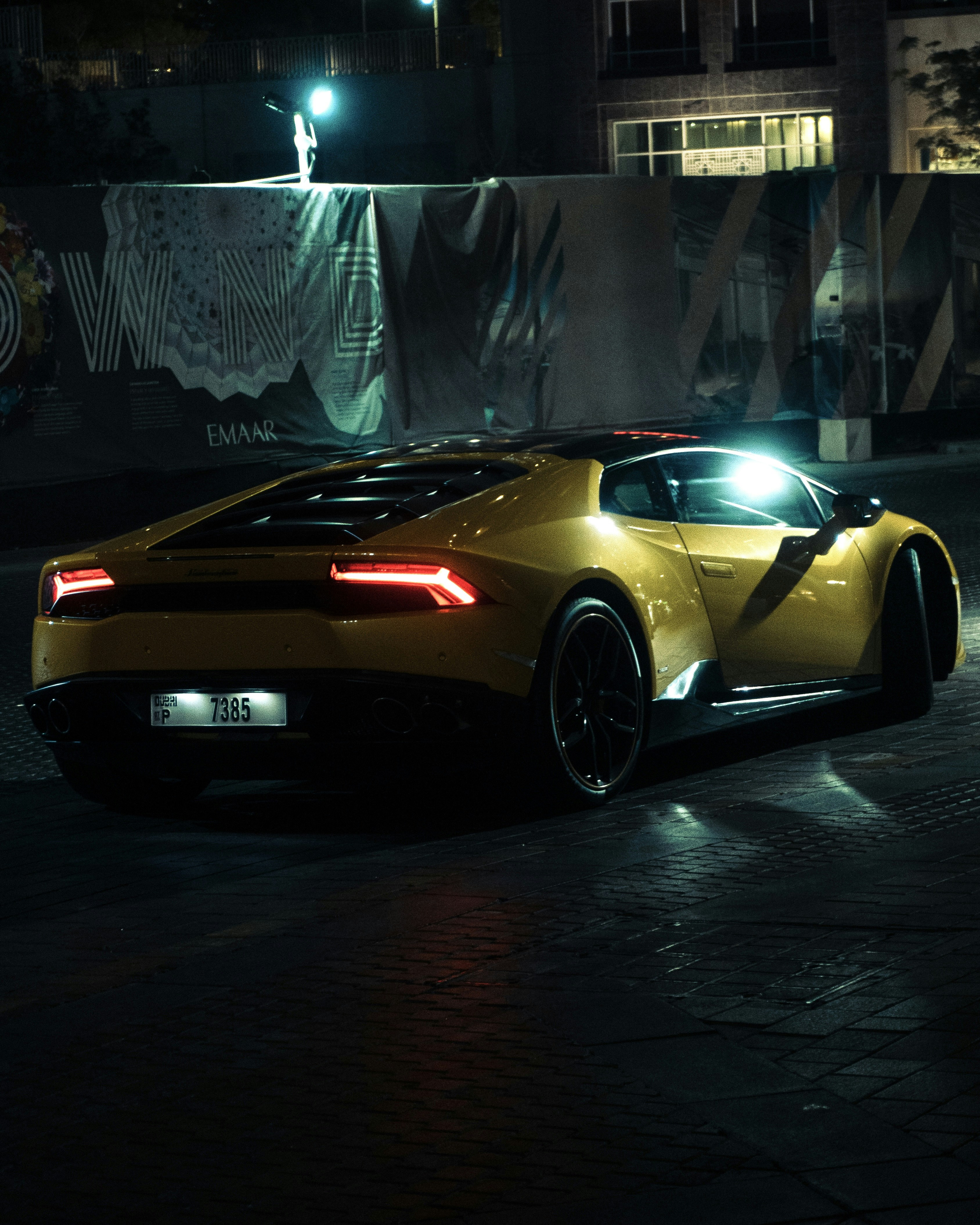 Sunburst Under Neon: A Yellow Lamborghini Halts on a Night-Tinted Street