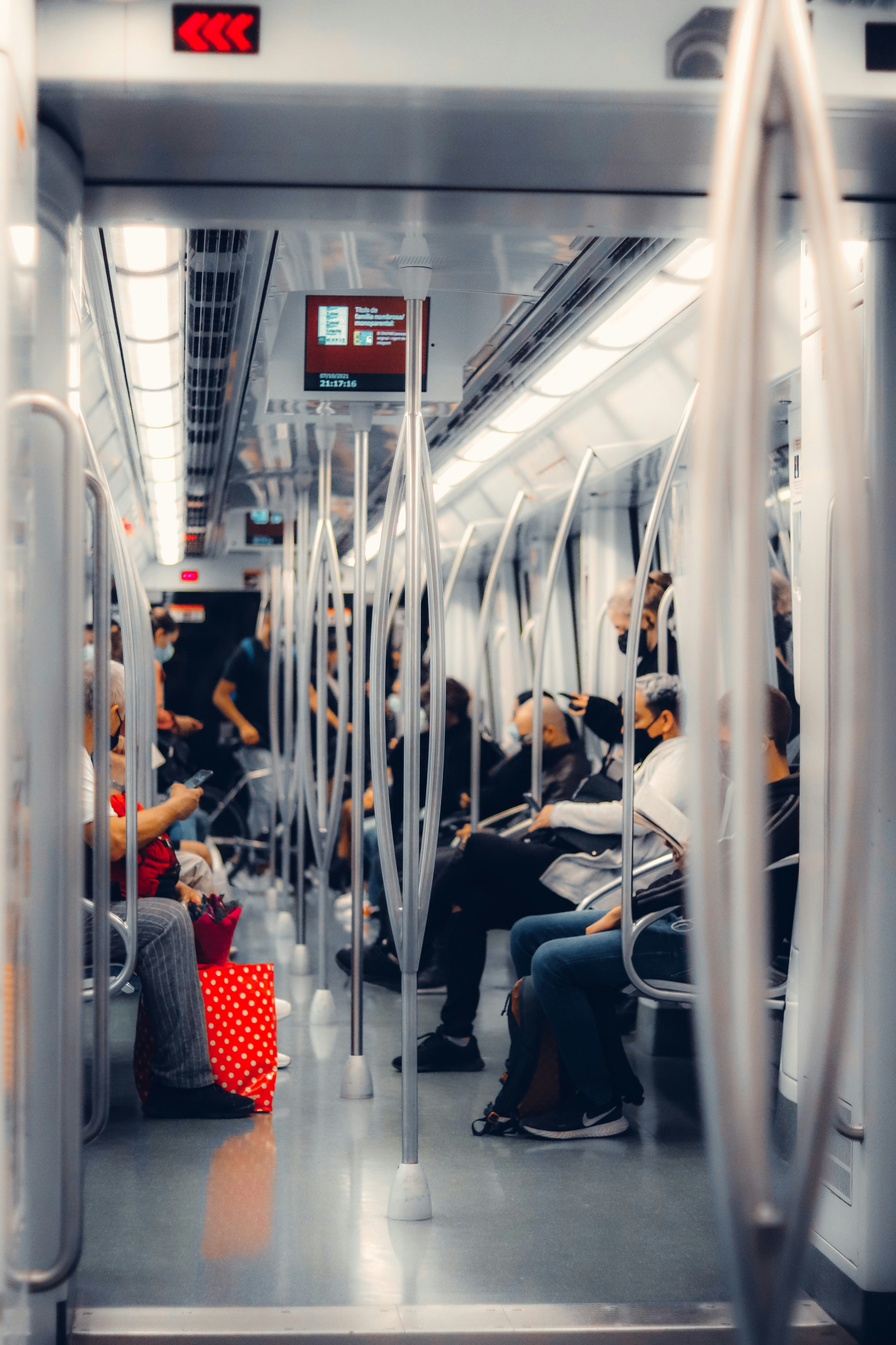 A group of people sitting on a train next to each other photo – Free ...