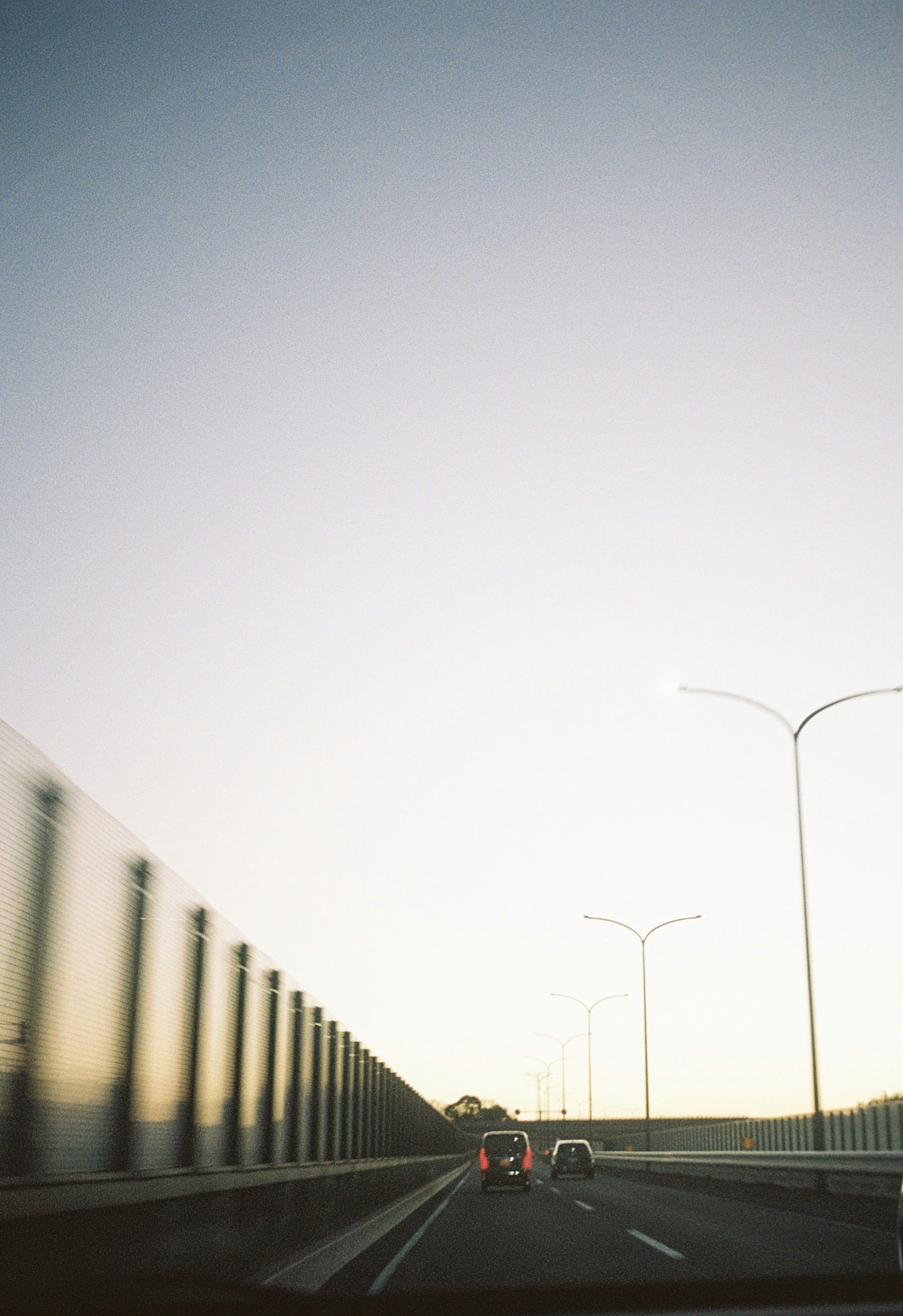 A car driving down a highway next to a traffic light photo – Free Film ...
