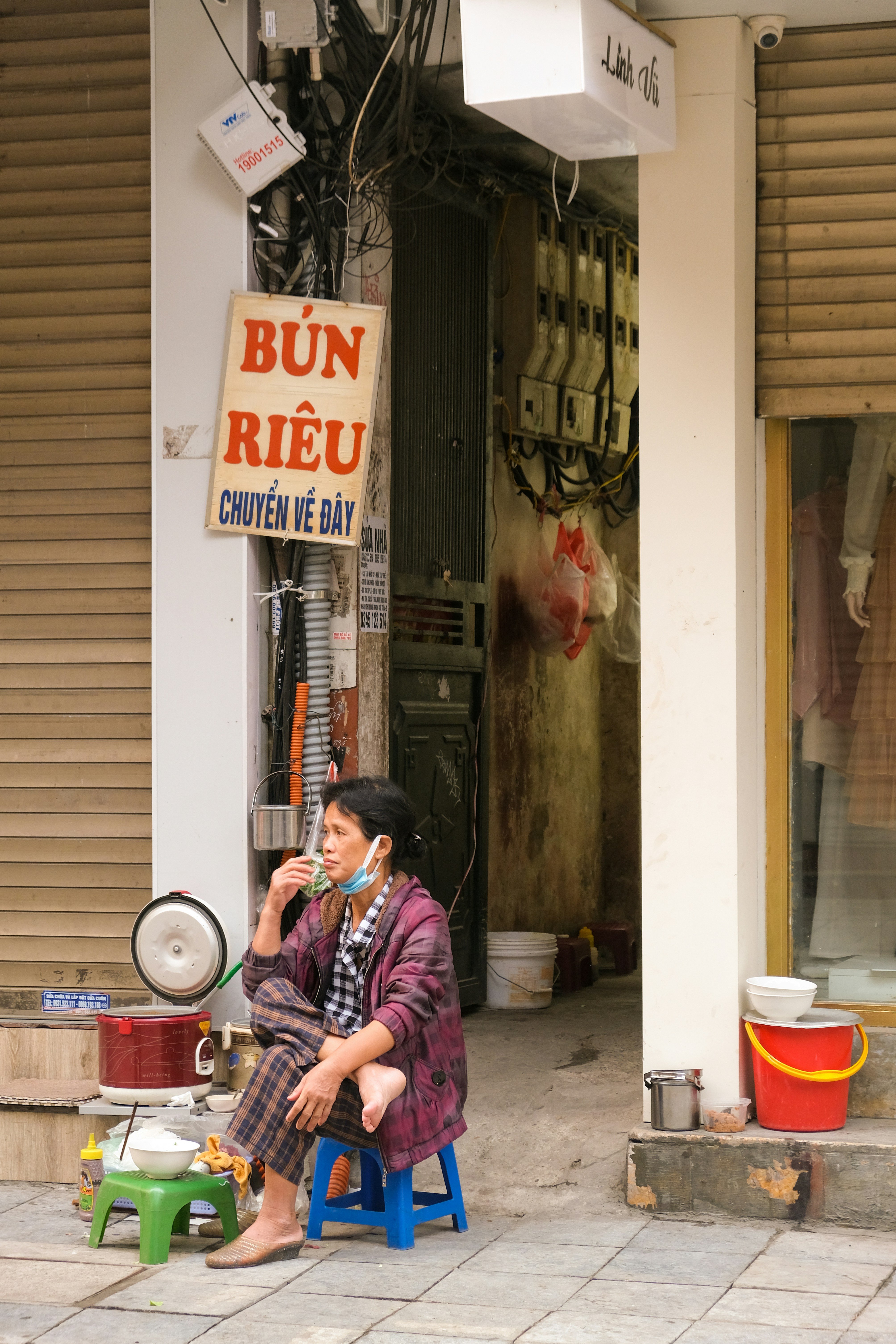 a woman sitting on a blue chair in front of a store