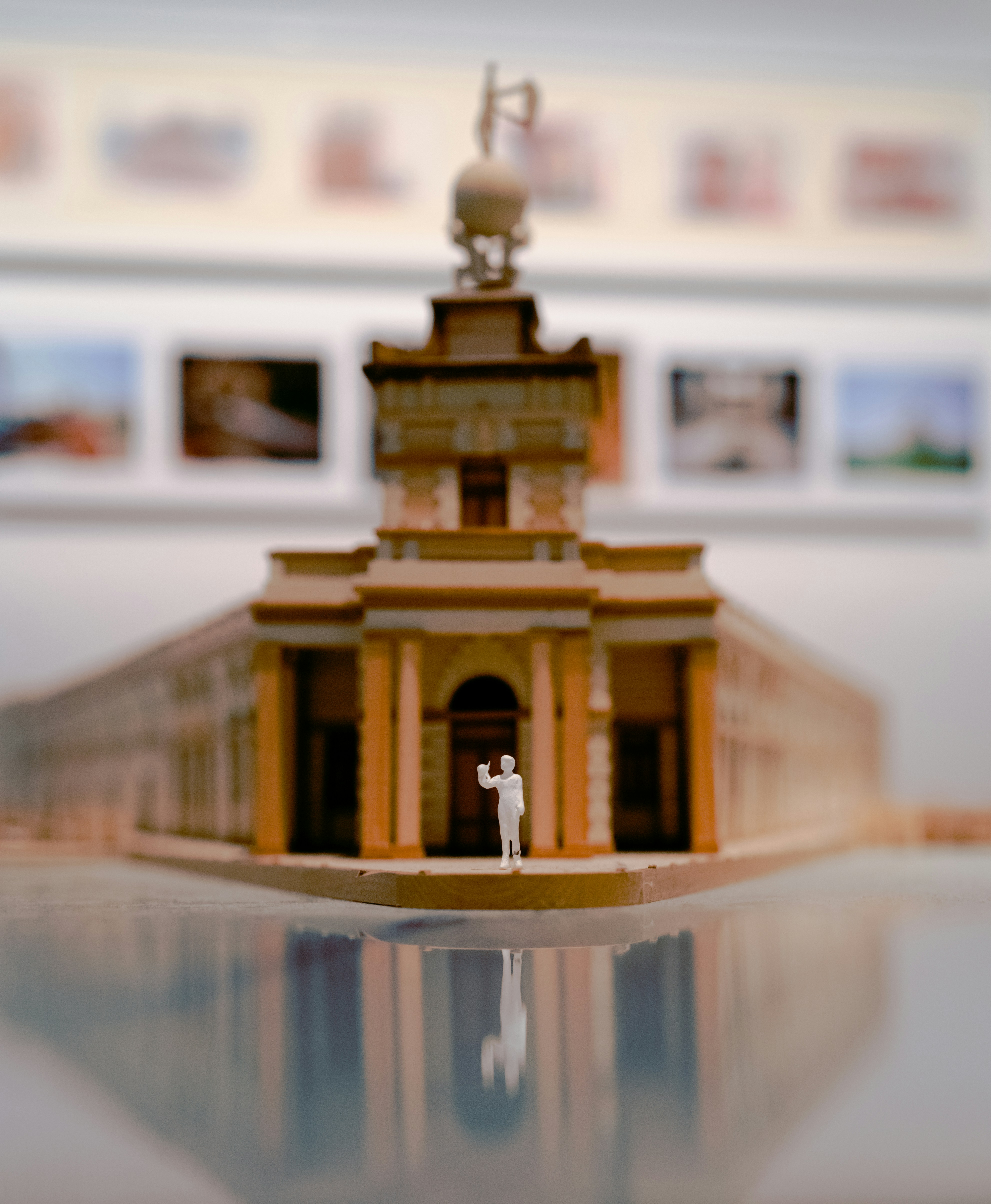 A small statue of a man standing in front of a building photo – Free ...