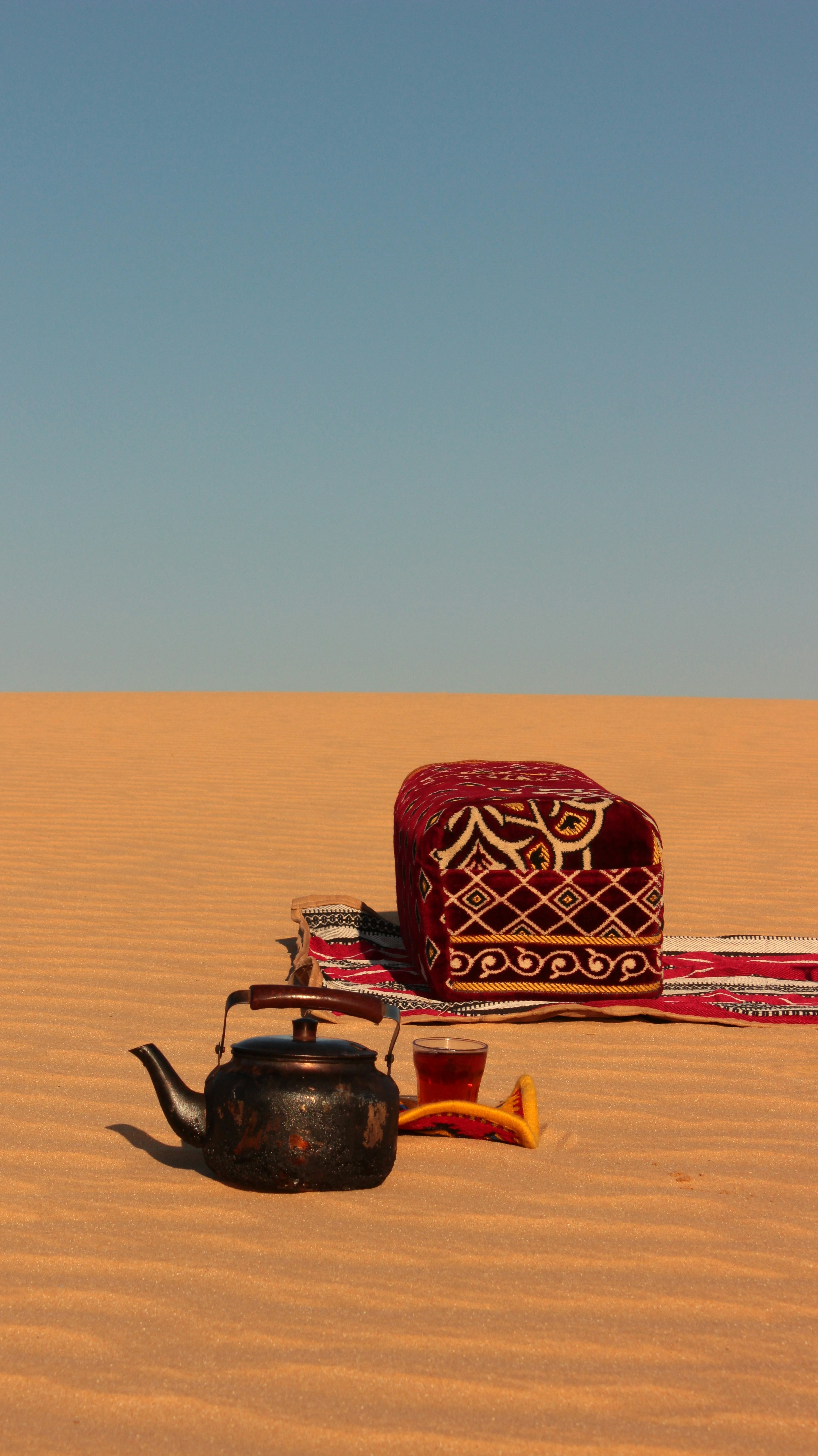 Desert Still Life: A Tea Kettle, Padded Mat, and Distant Sky