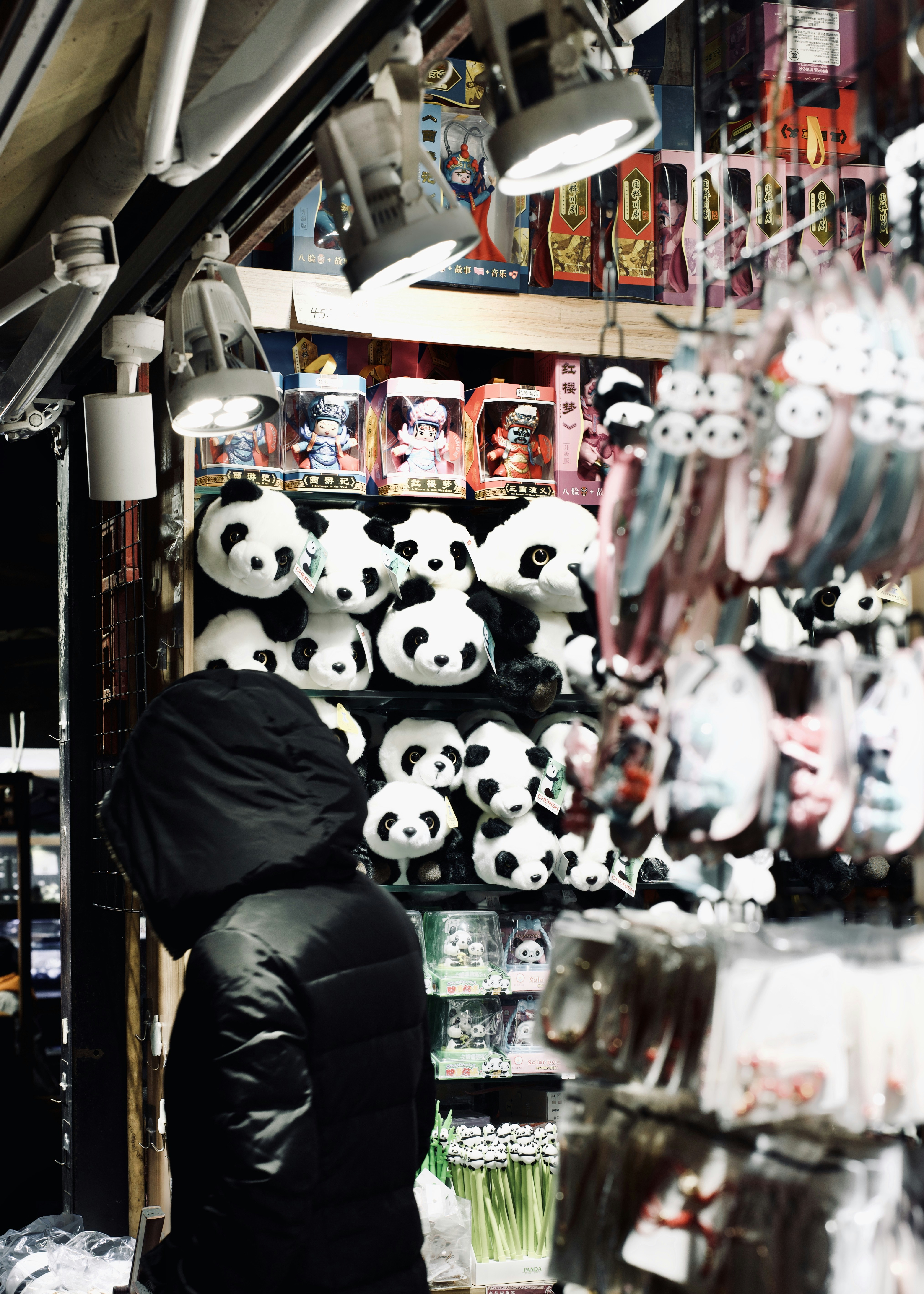 a person in a black jacket standing in front of a store