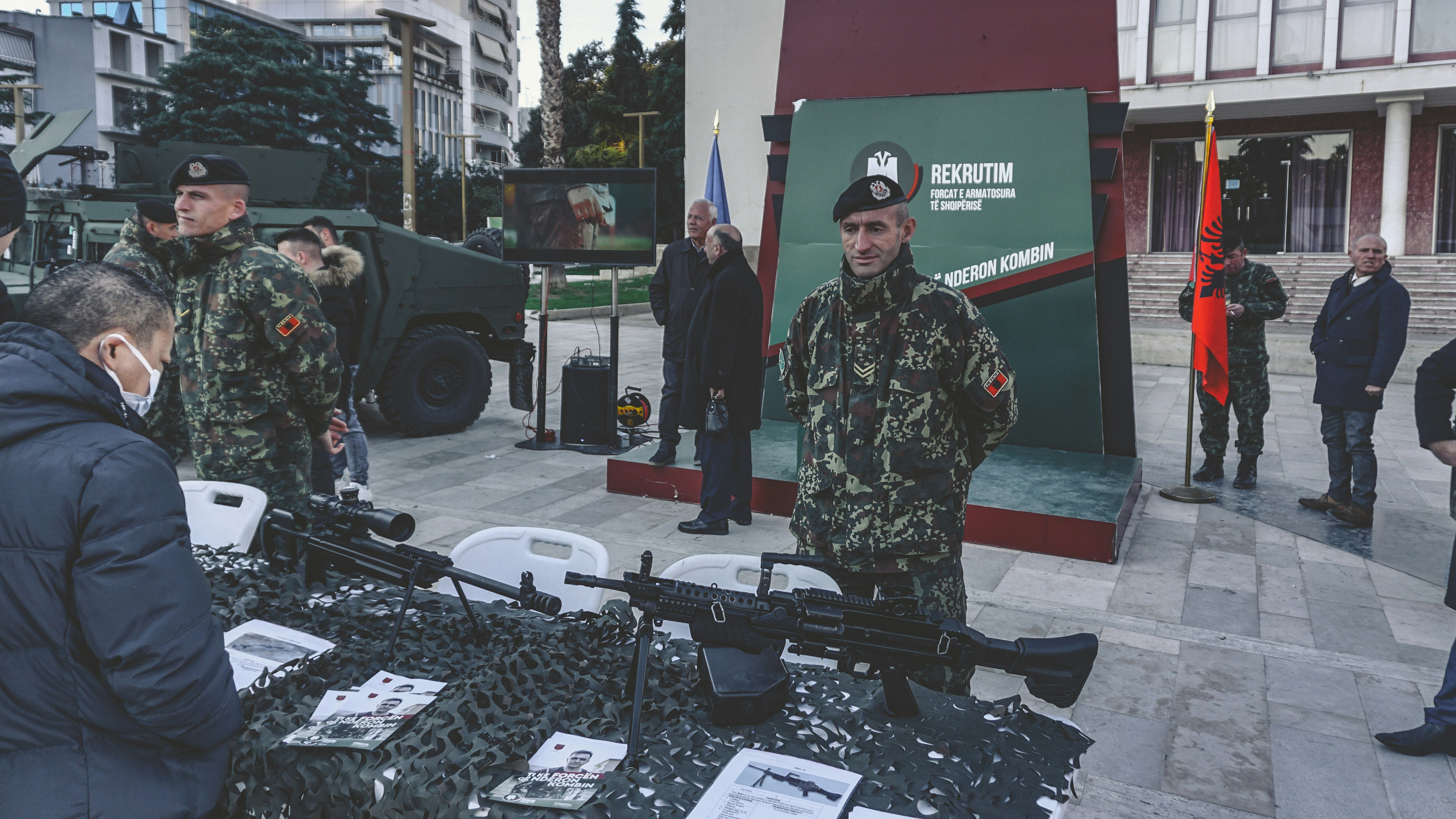A group of men standing around a table with guns photo – Free Human ...
