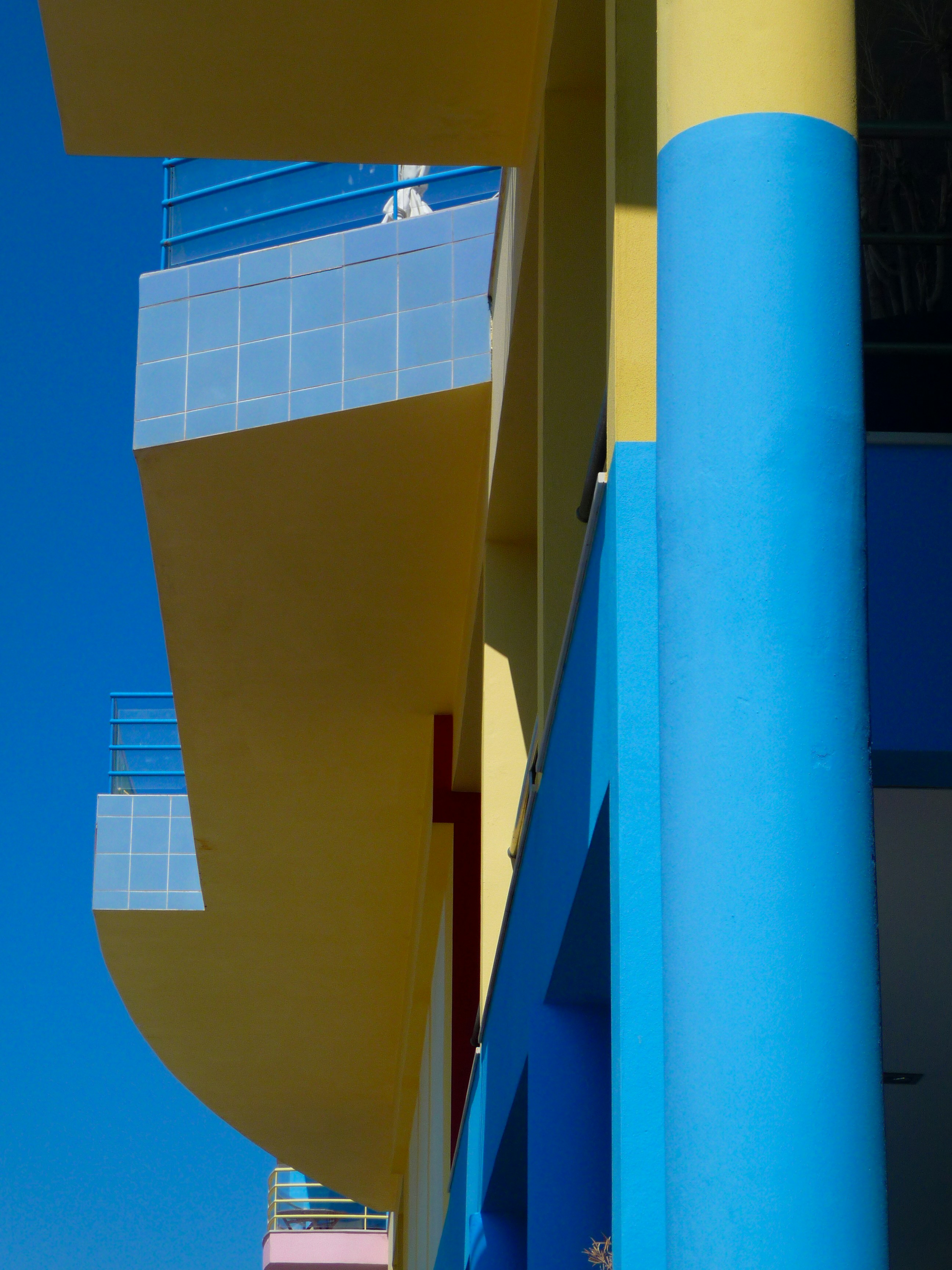 Vibrant architectural details showcasing colorful balconies and bold structural lines against a clear blue sky.