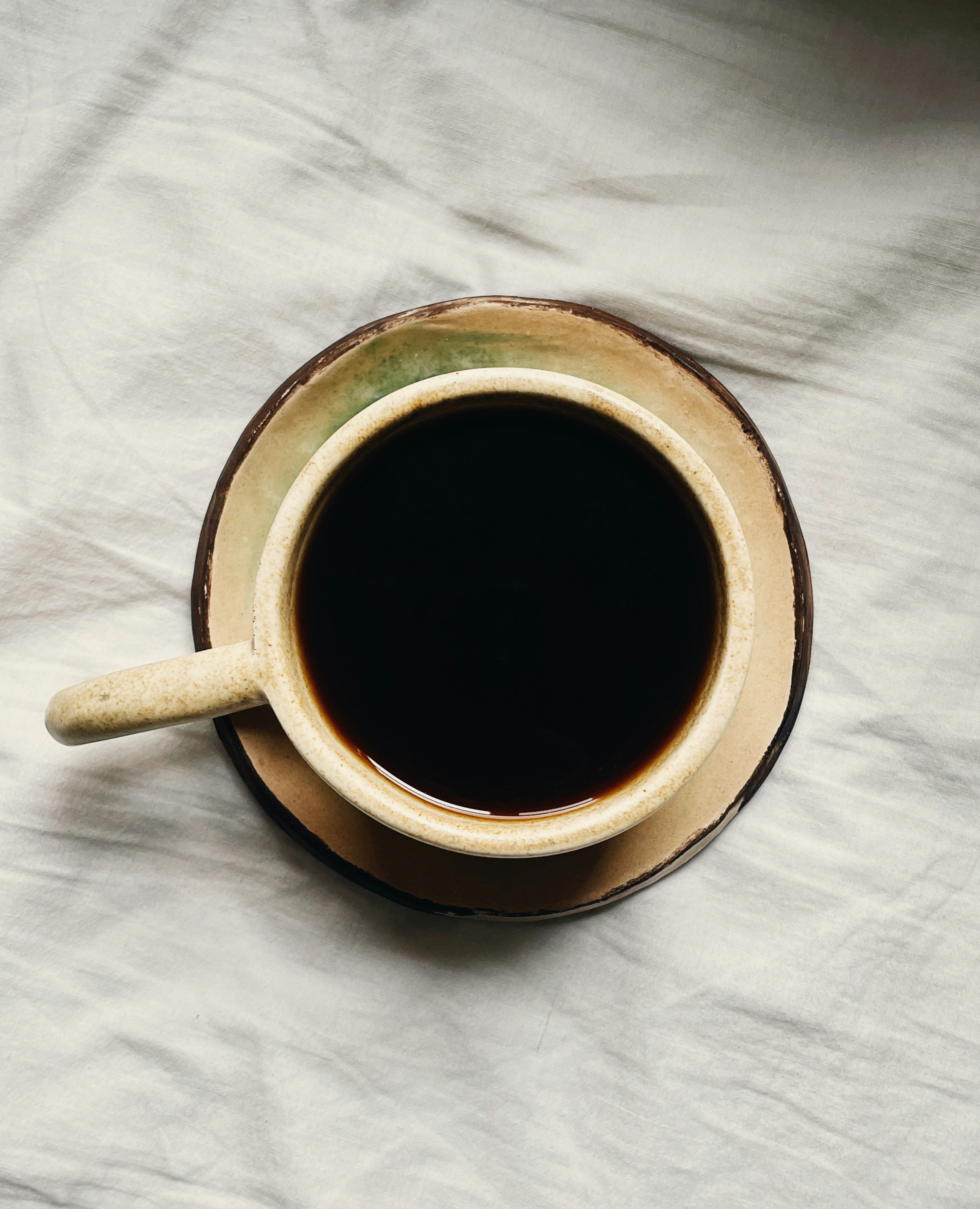 Une tasse de café est assise sur un drap blanc photo – Image gratuite ...