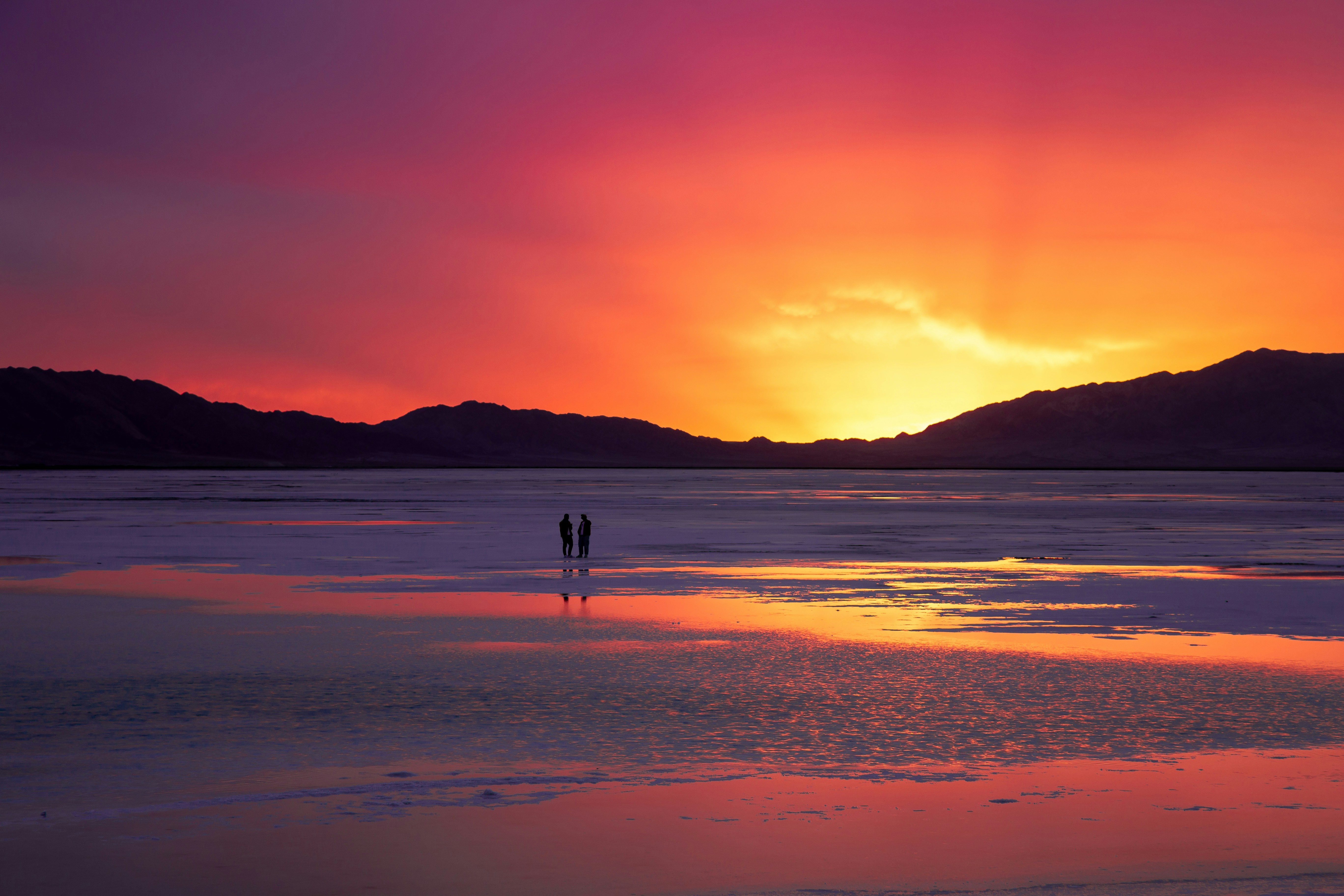 Twin Silhouettes on a Glowing Salt Flat at Sunset