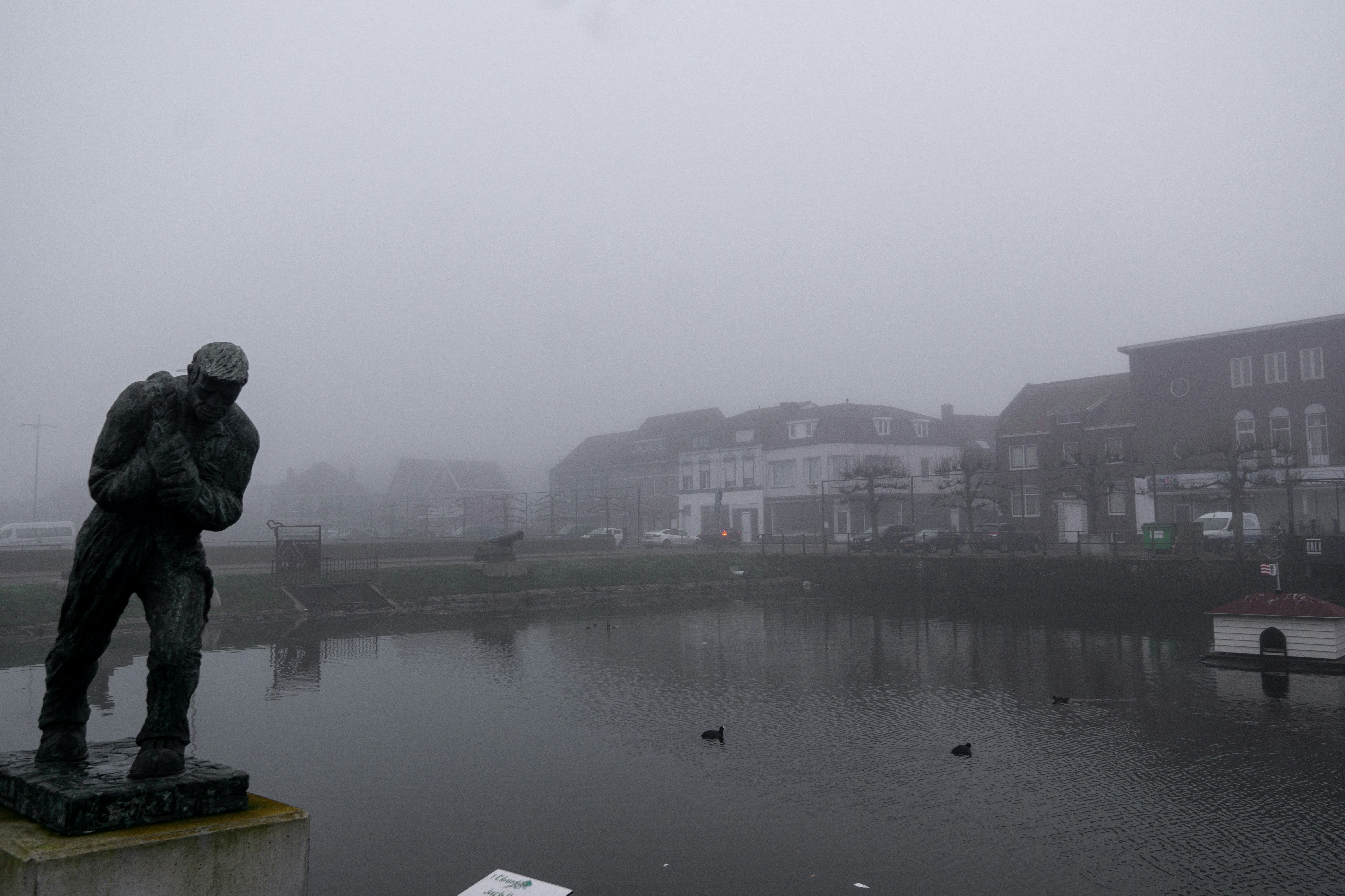 Une statue d’un homme debout devant un plan d’eau photo – Photo ...