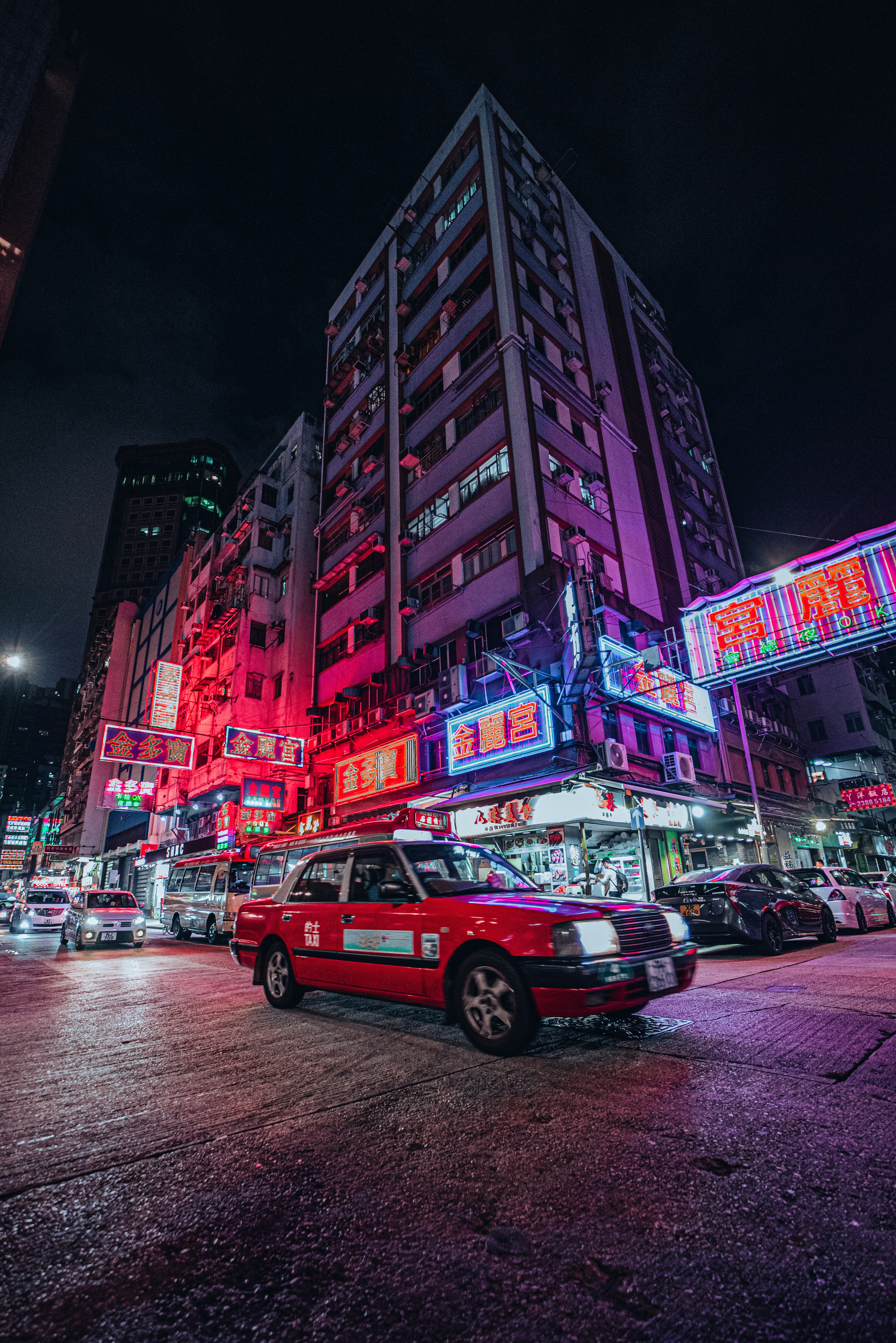 Un taxi rojo conduciendo por una calle junto a edificios altos foto – Imagen de Hong Kong ...