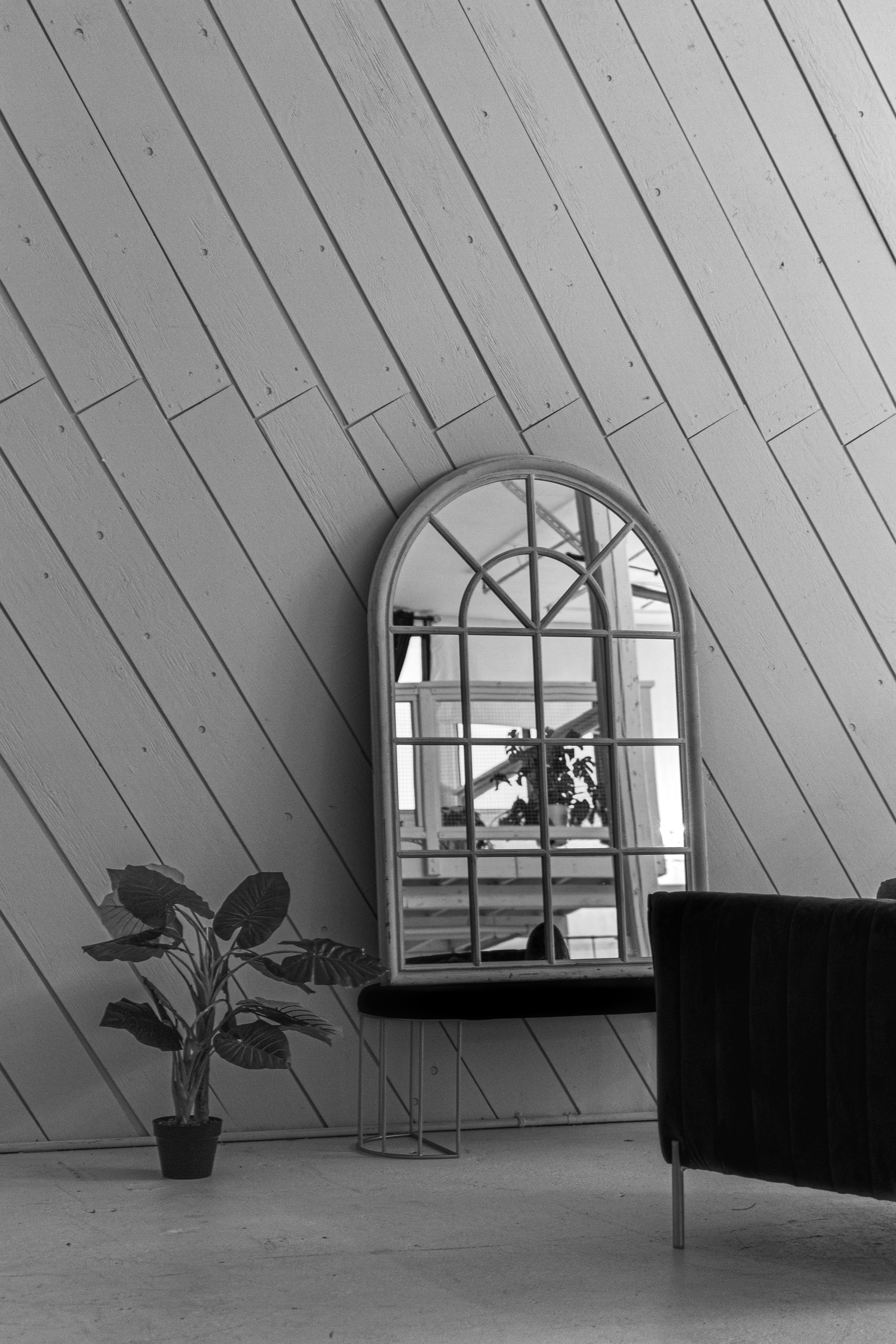 a black and white photo of a chair and a mirror