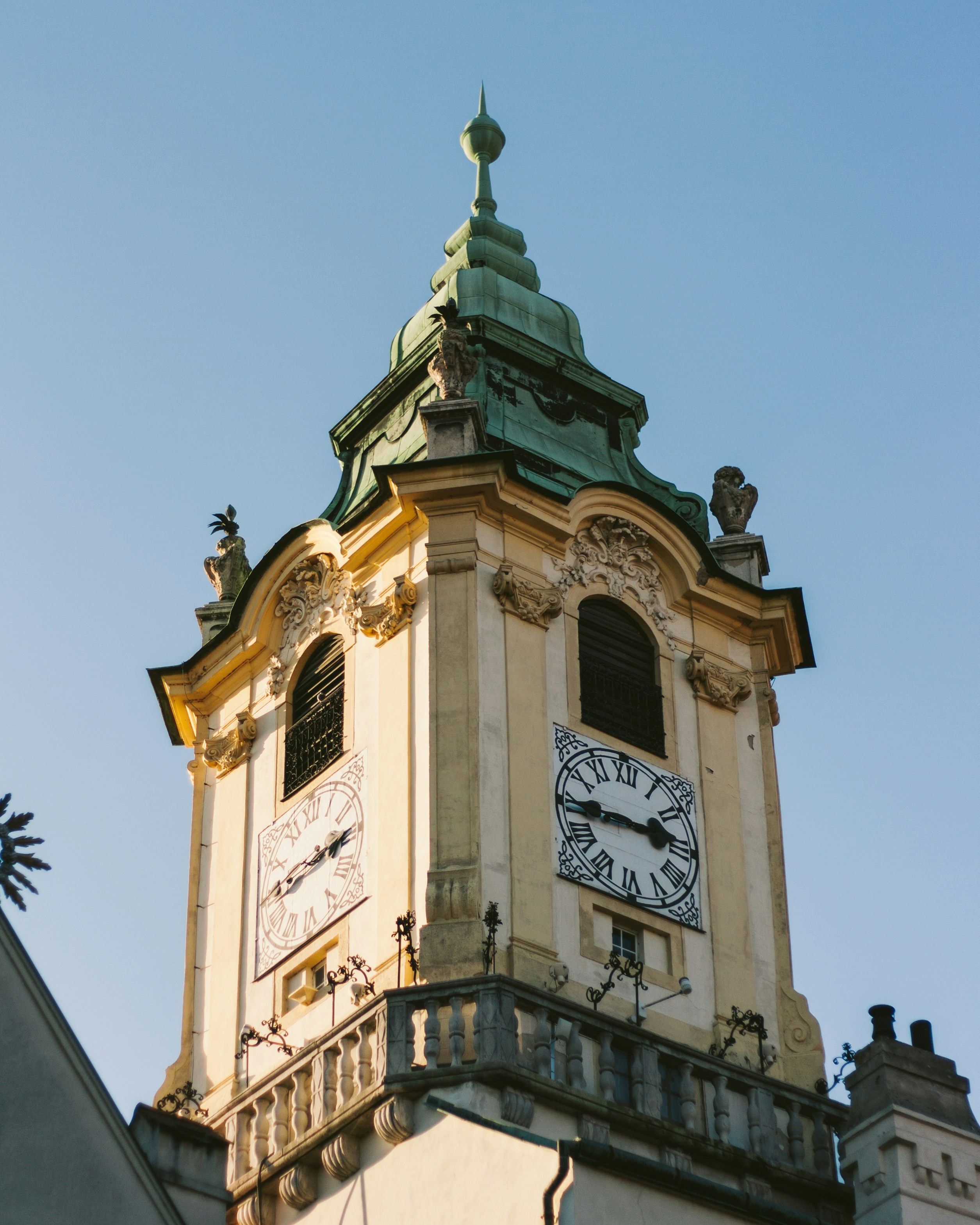 Historic clock tower adorned with intricate details and dual clock faces against a clear blue sky.