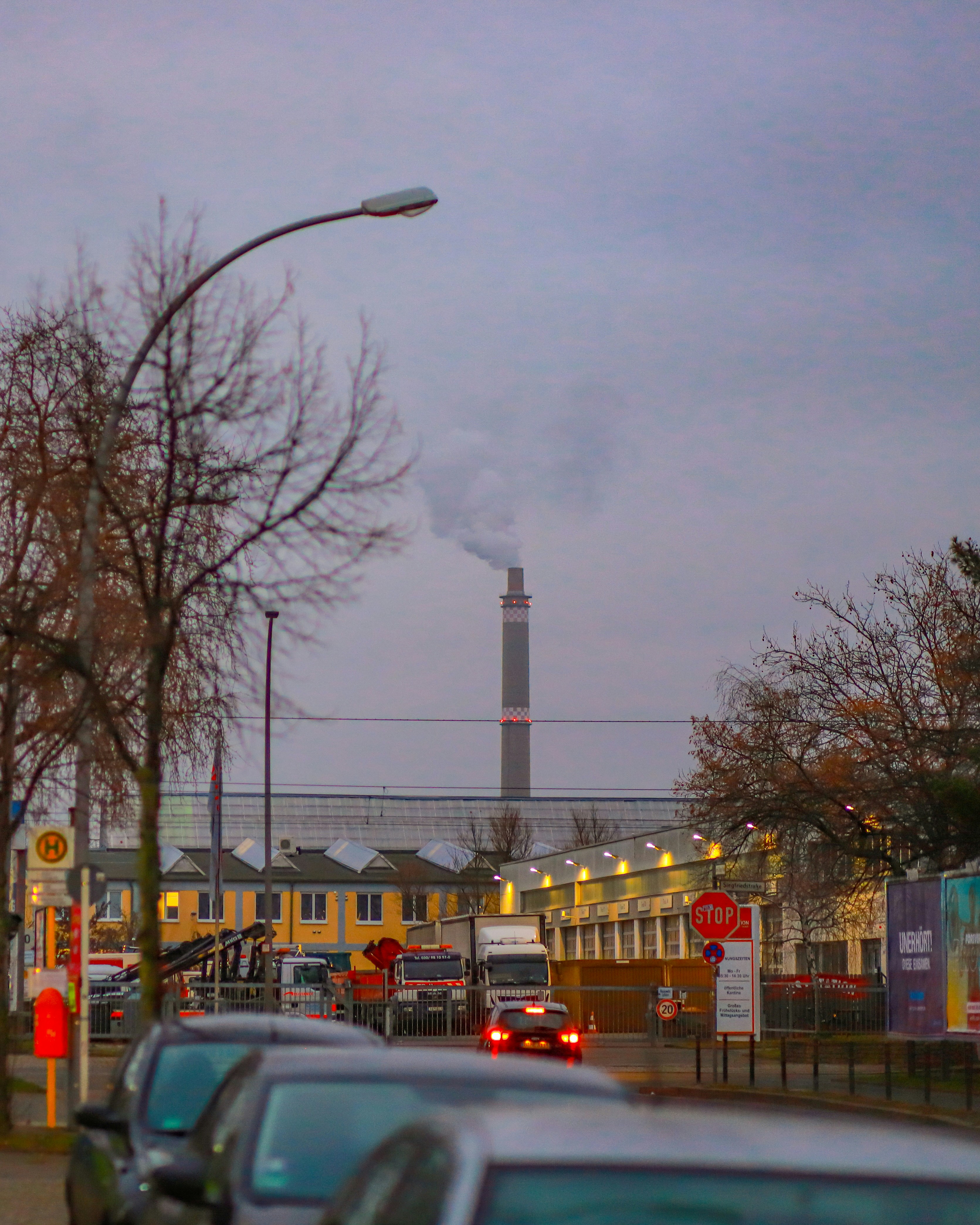 Smokestack Skyline: A Quiet Street Beneath an Industrial Tower