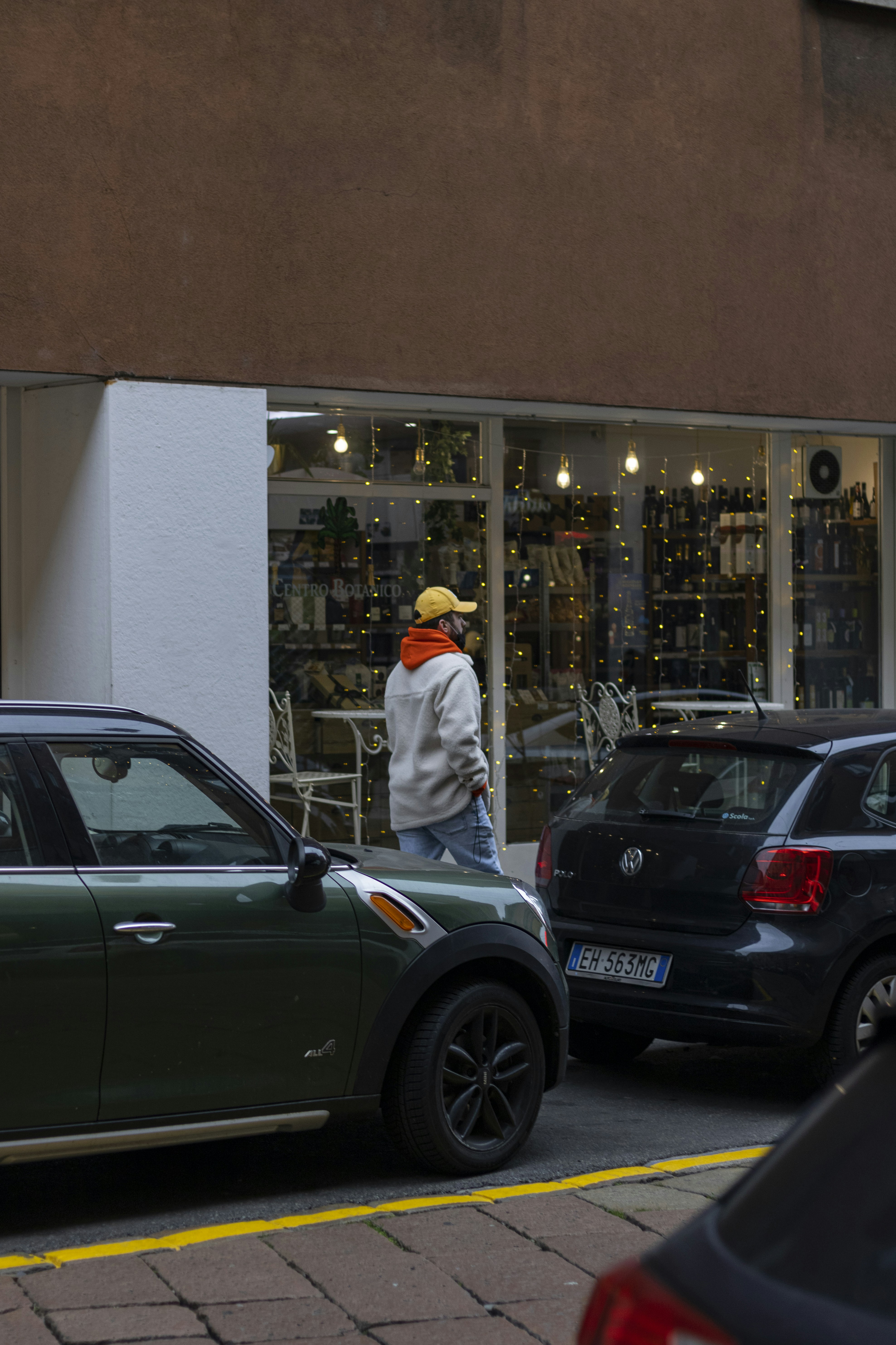 a man walking down the street in front of a store