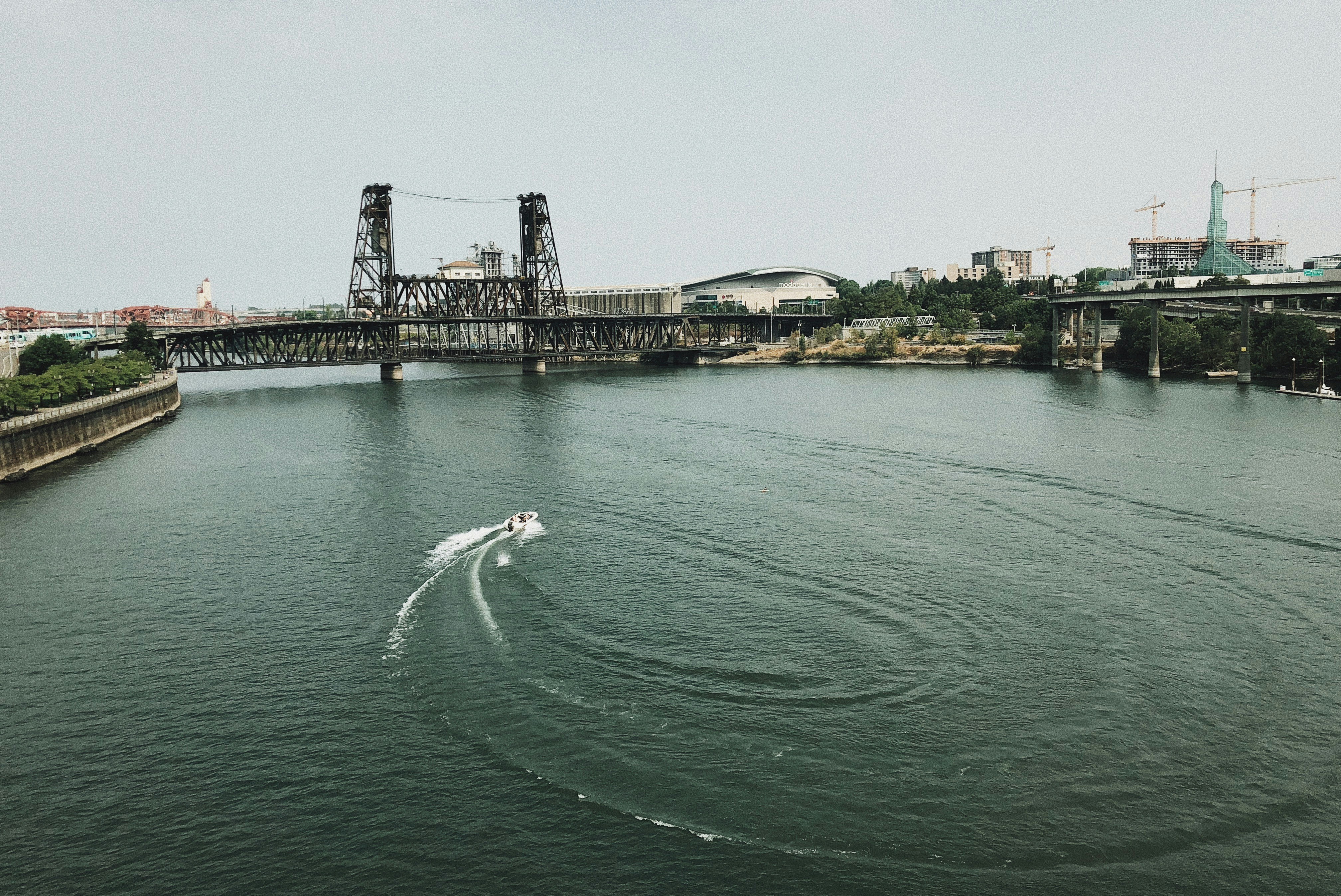 Foto Un barco que viaja por un río junto a un puente – Imagen Portland ...