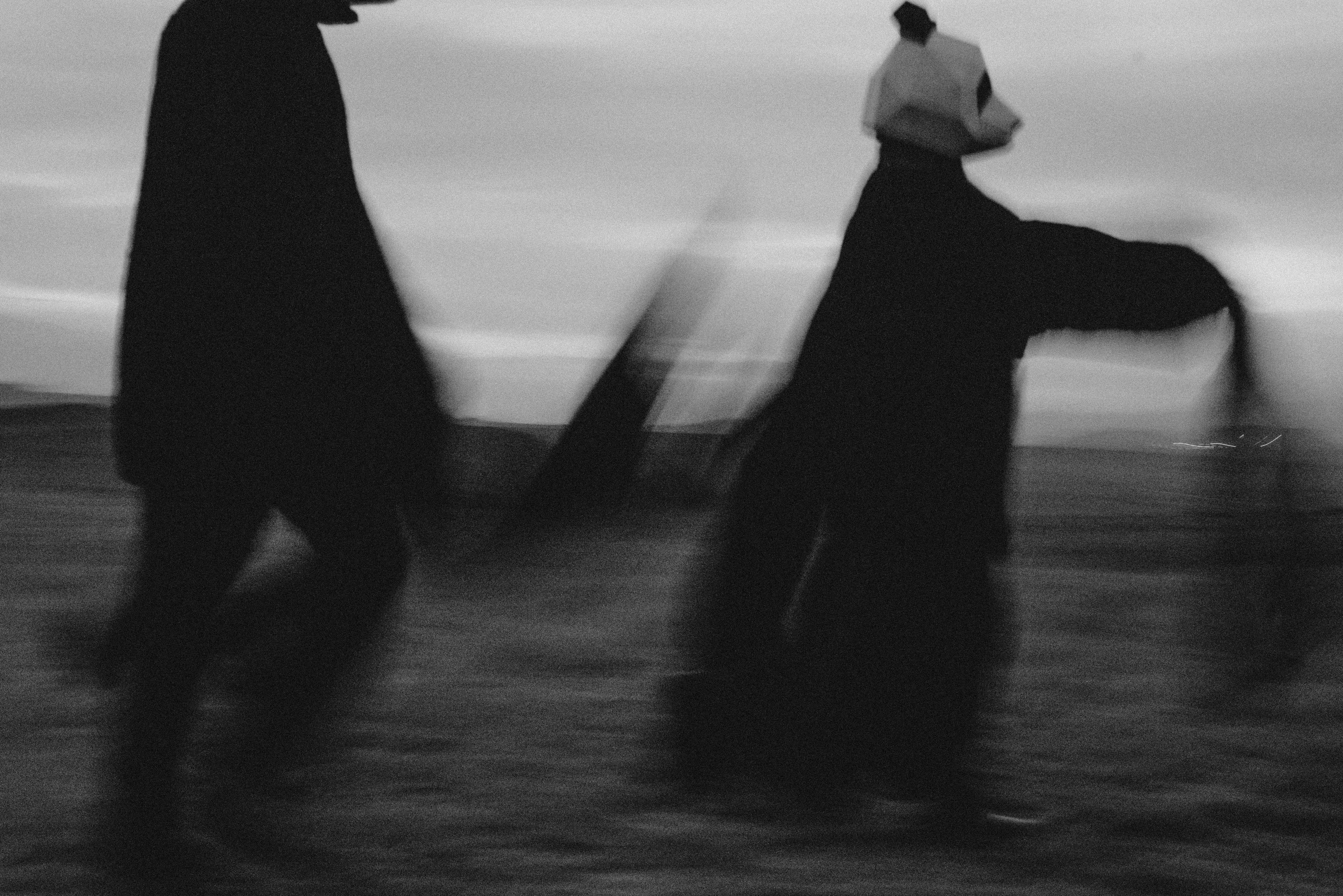 Spectral Dunes: Blurred Figures on a Wind-Swept Beach at Dusk