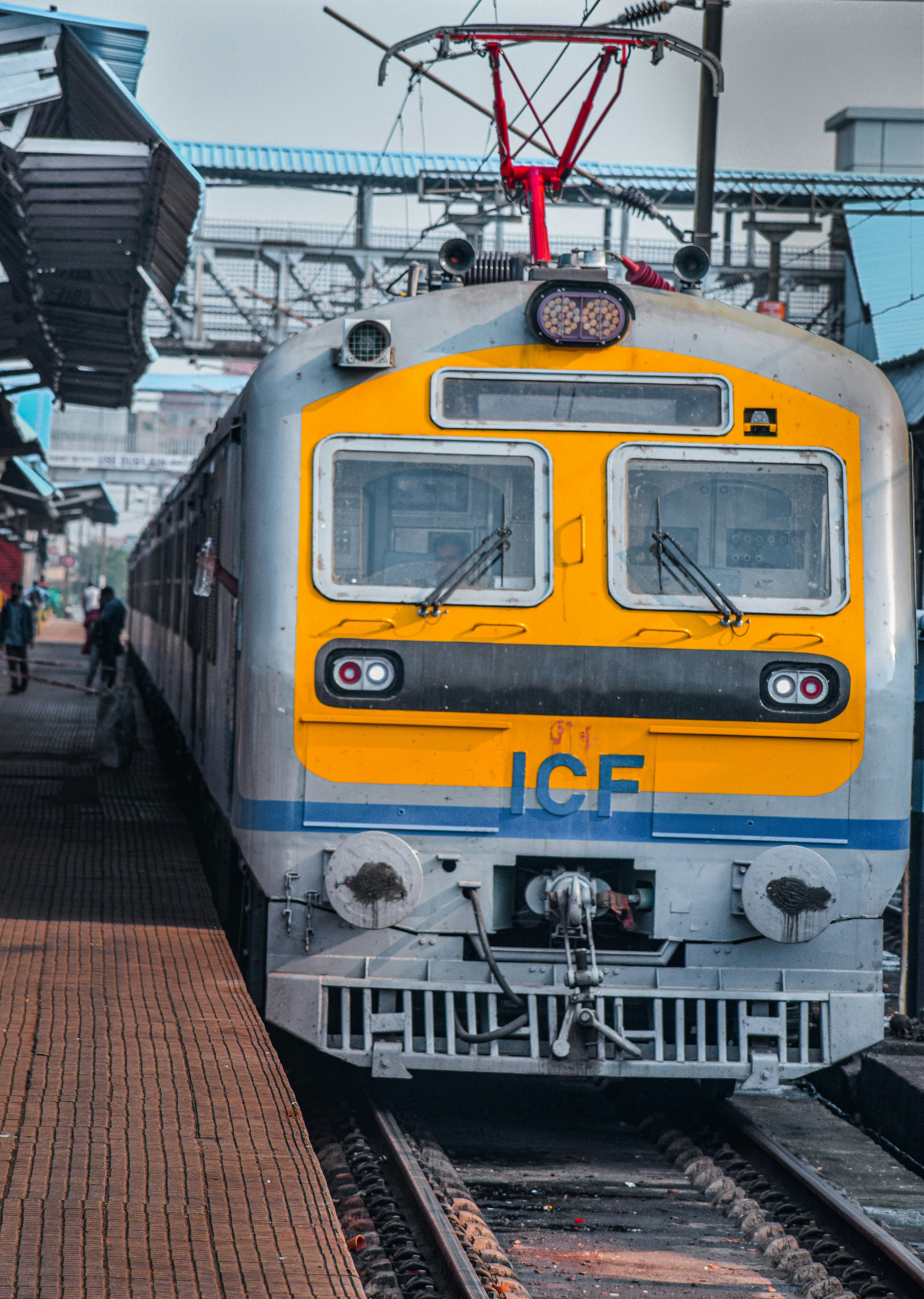 A yellow and silver train pulling into a train station photo – Free ...